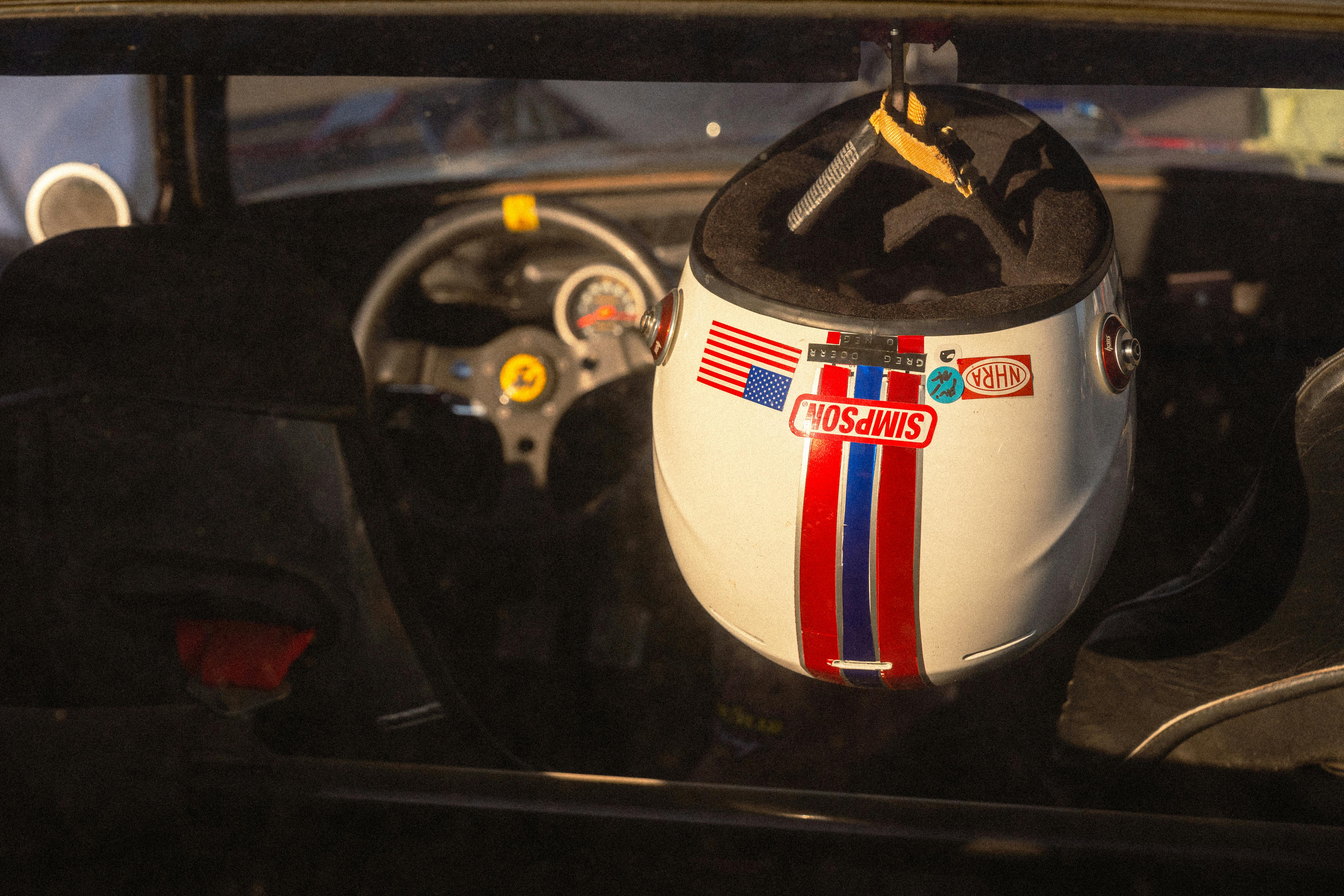 A helmet with a racing stripe on it sits in the cockpit of a car · Free ...