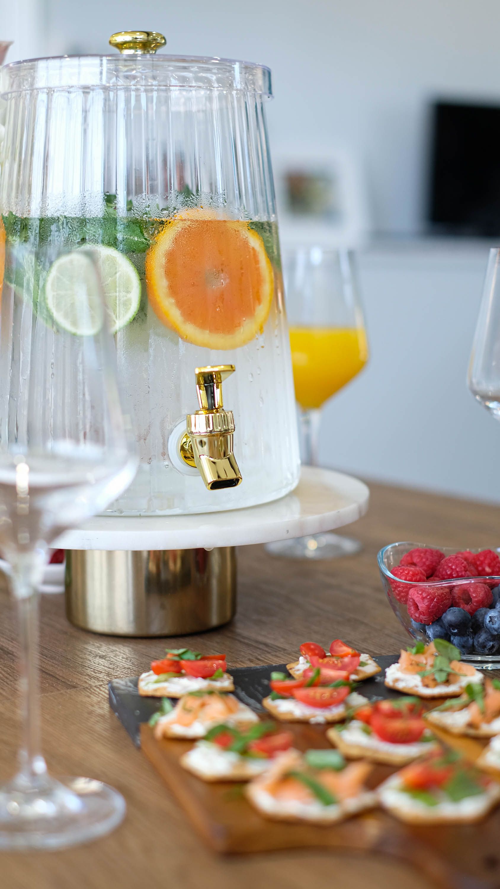 A glass of water with fruit and a plate of snacks · Free Stock Photo