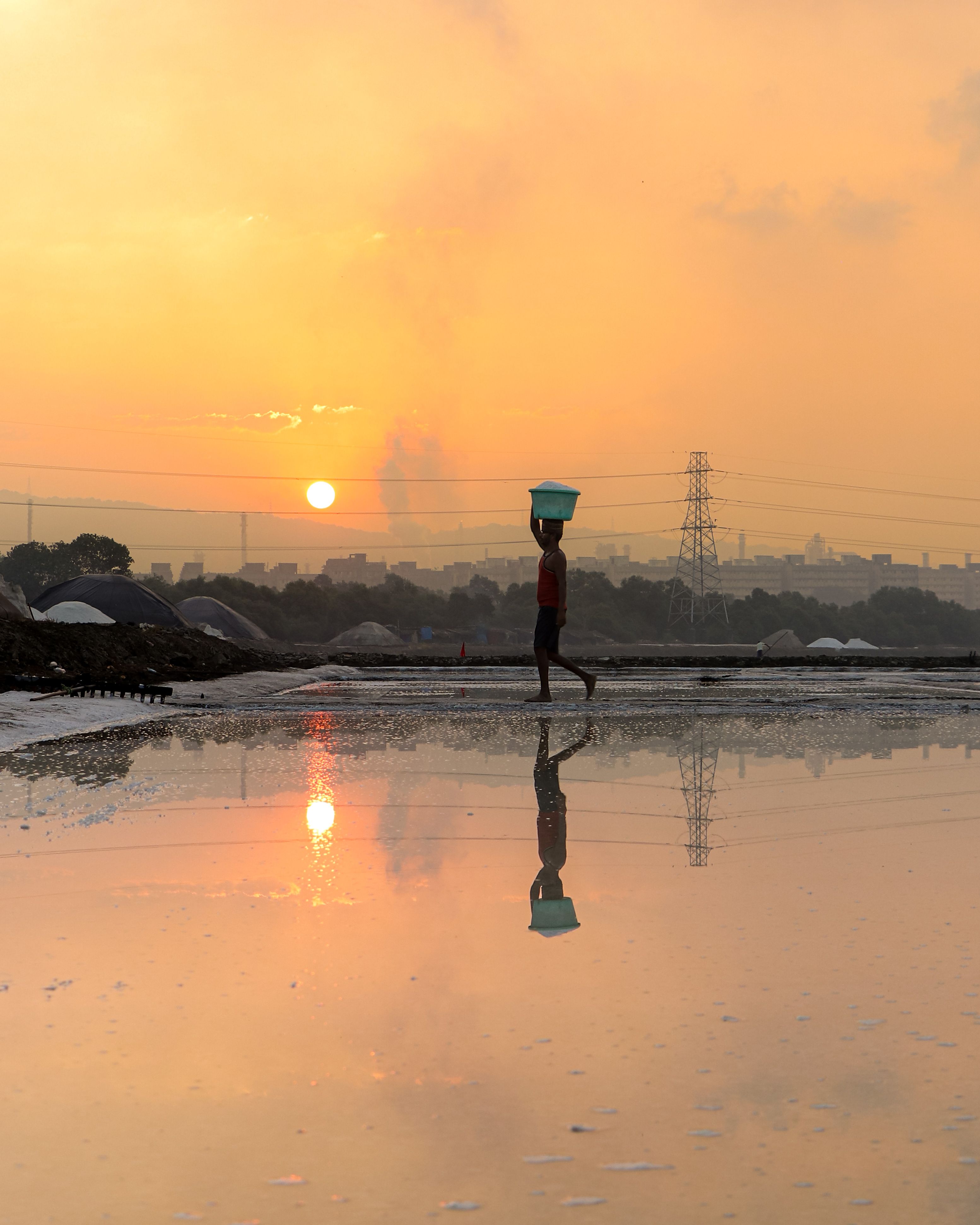 A person walking across a field with a bucket · Free Stock Photo
