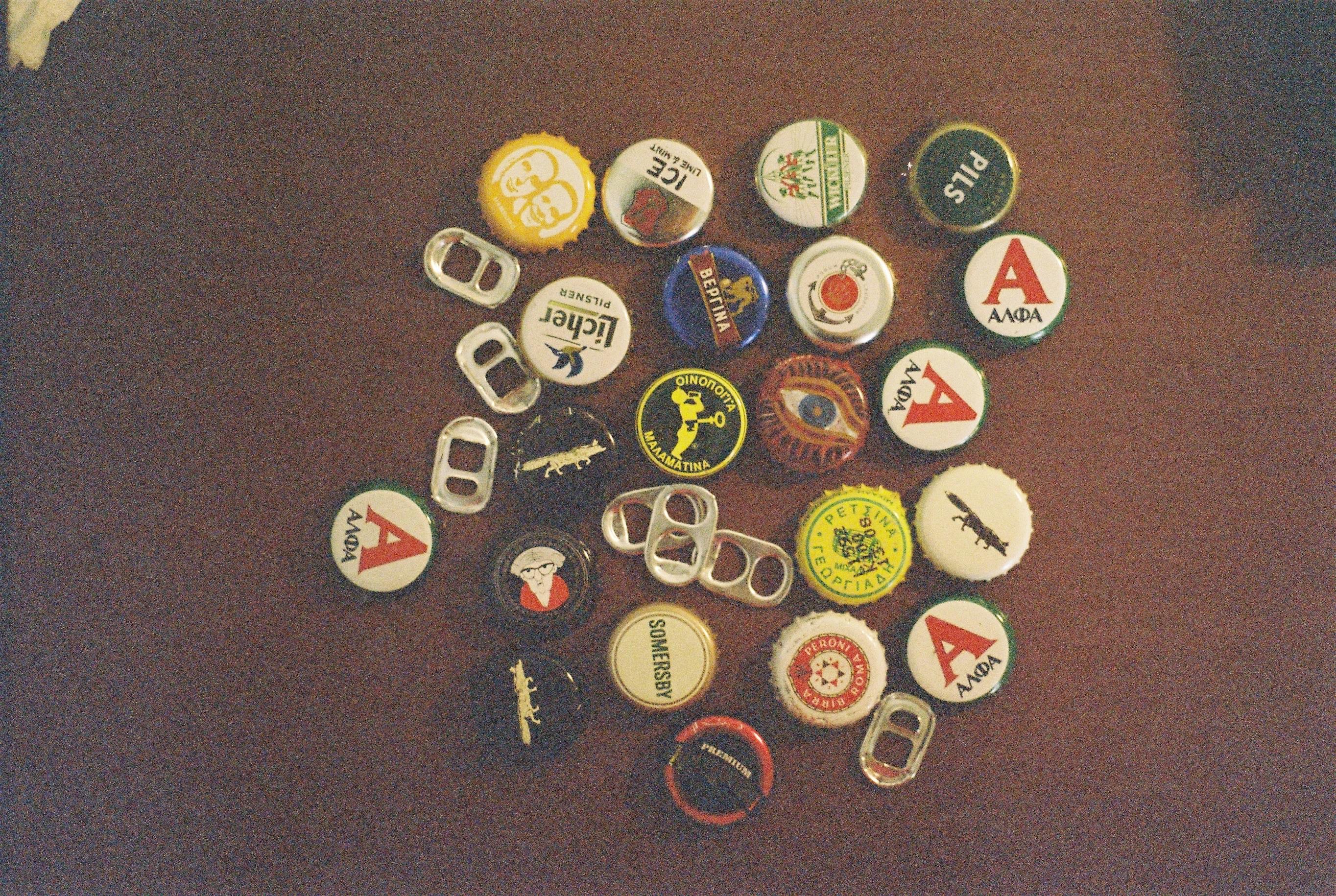 A bunch of different types of bottle caps on a table · Free Stock Photo