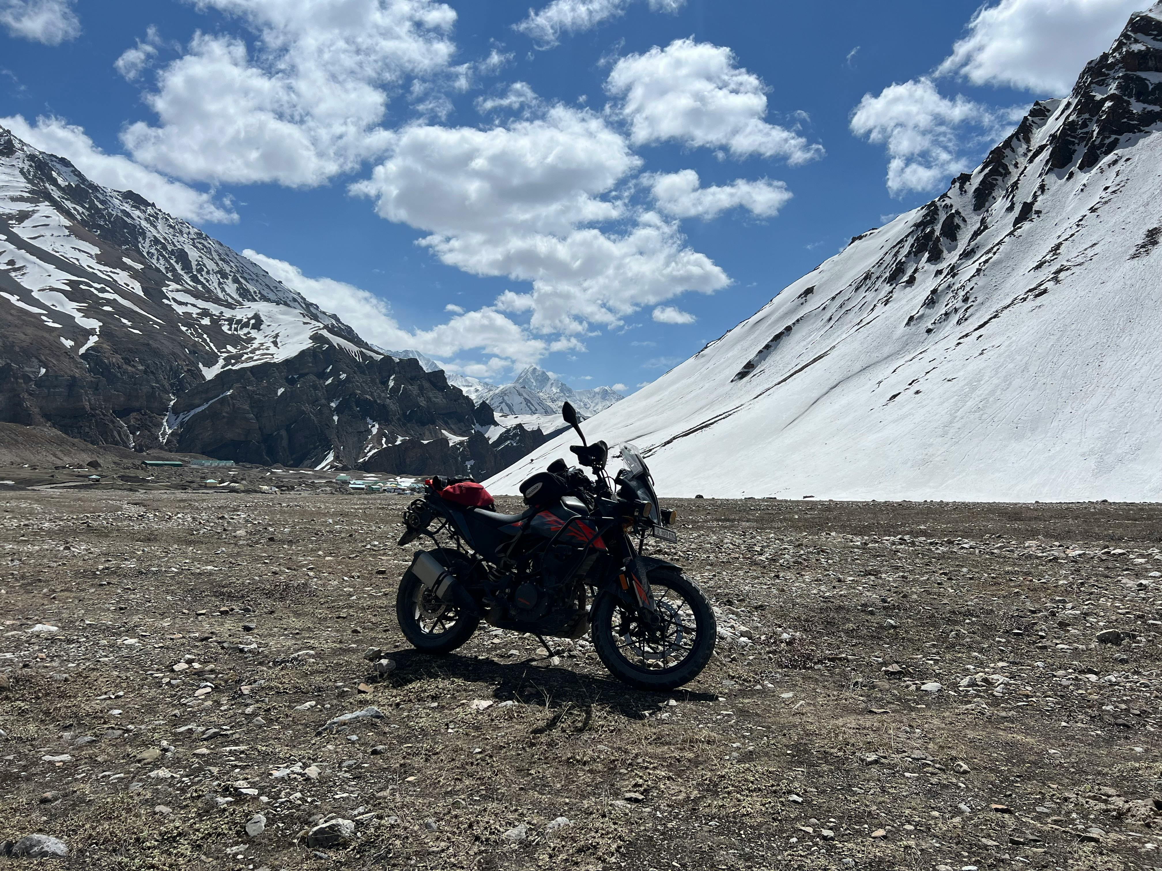 A motorcycle parked in the middle of a barren field · Free Stock Photo