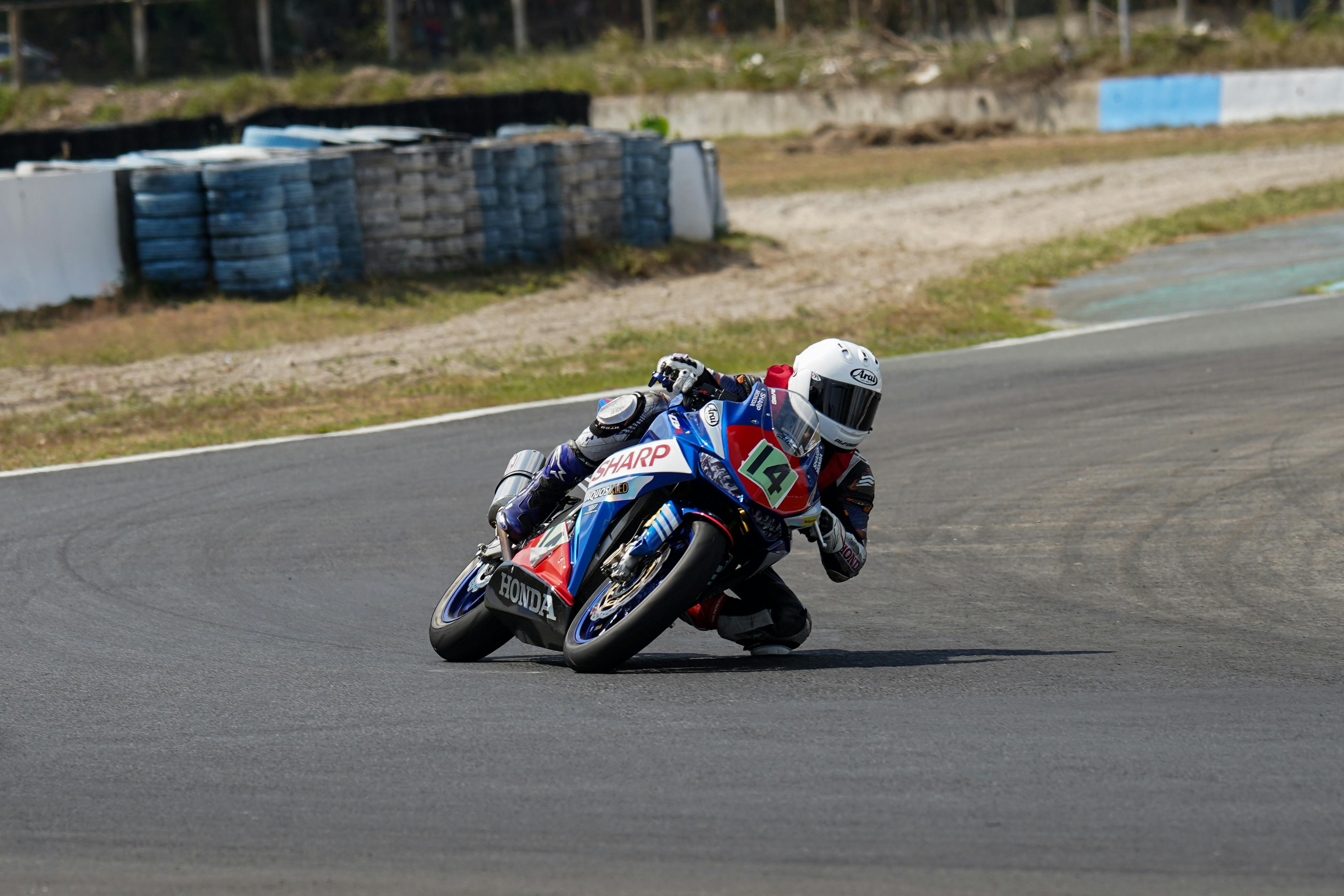 A person riding a motorcycle on a race track · Free Stock Photo