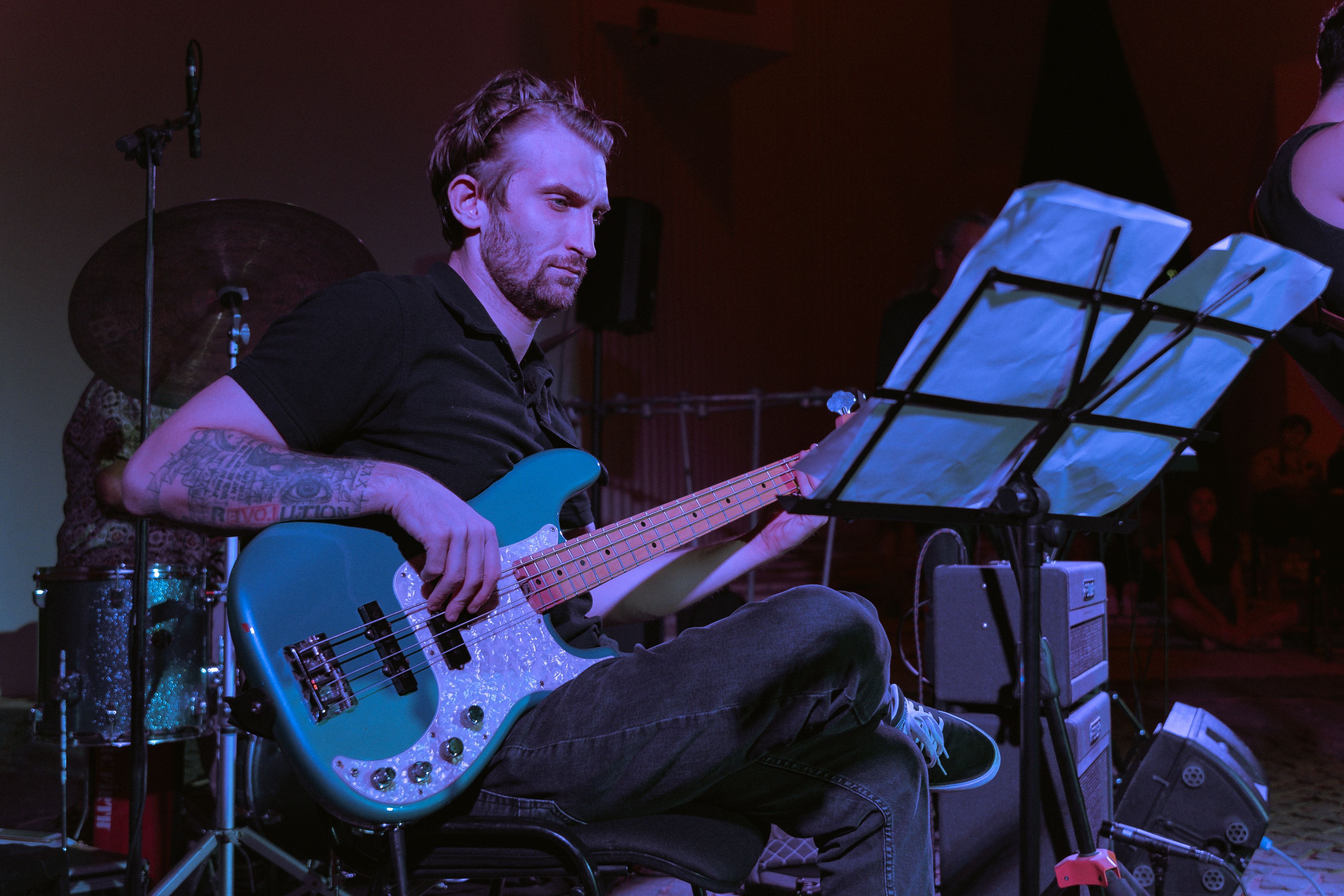 A man playing a bass guitar in a music studio · Free Stock Photo