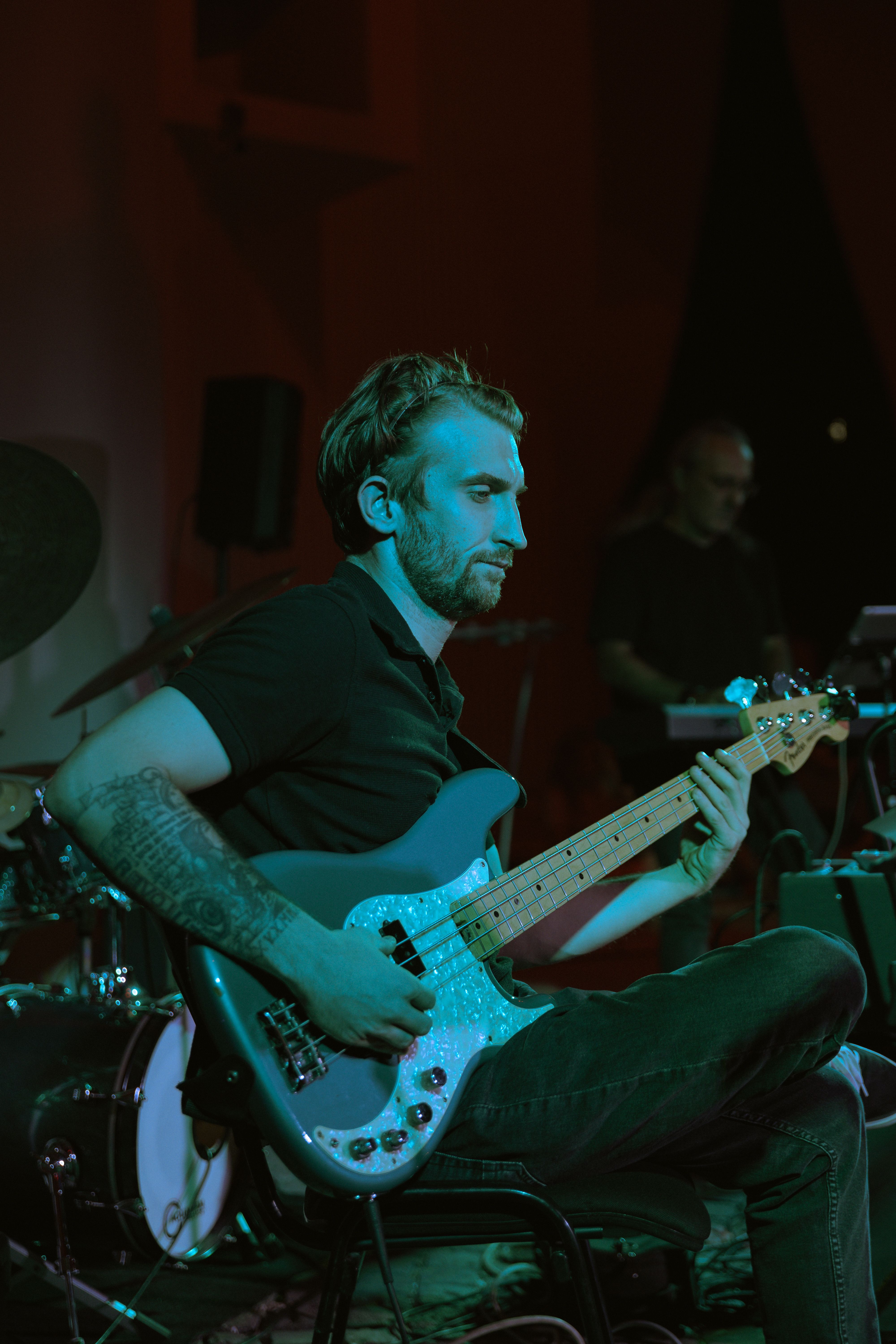 A man playing a bass guitar in a band · Free Stock Photo