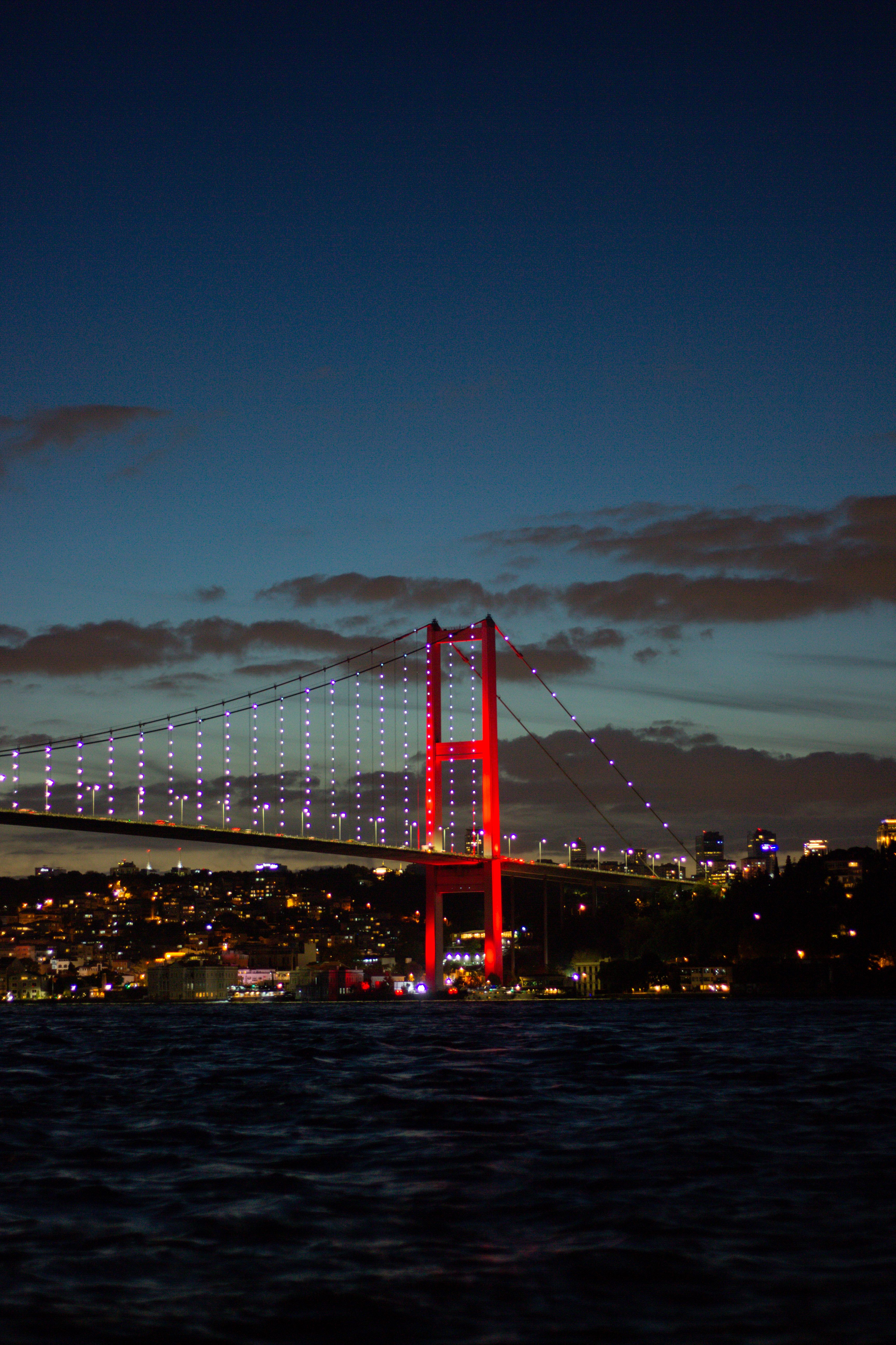 A red bridge is lit up at night · Free Stock Photo