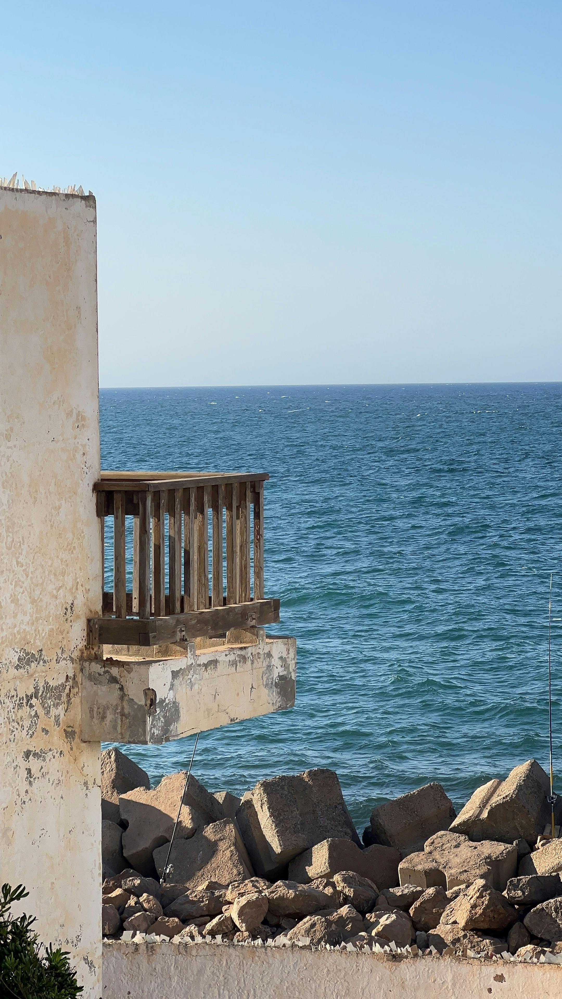 A balcony overlooking the ocean with a railing · Free Stock Photo