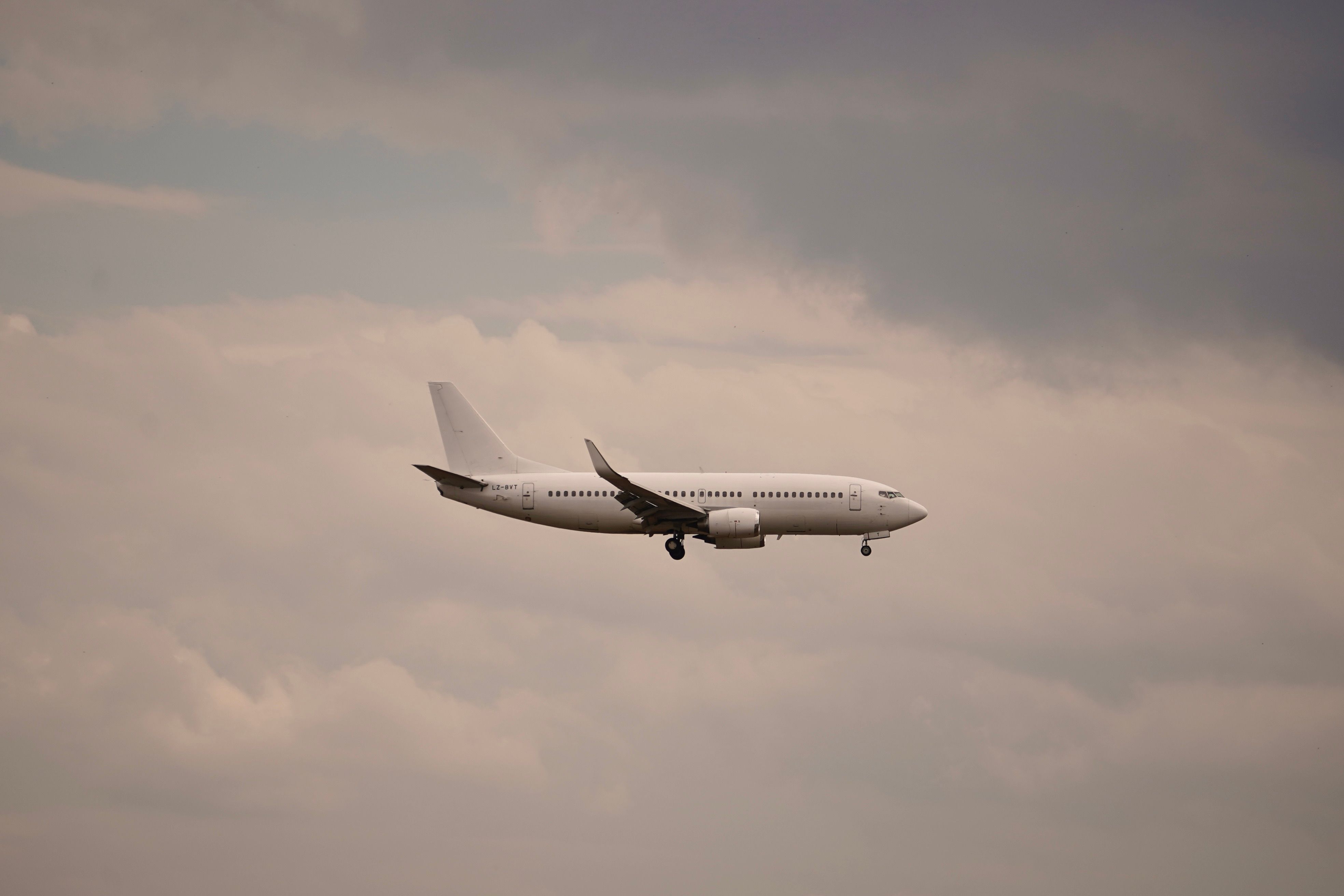 A large passenger jet flying through a cloudy sky · Free Stock Photo