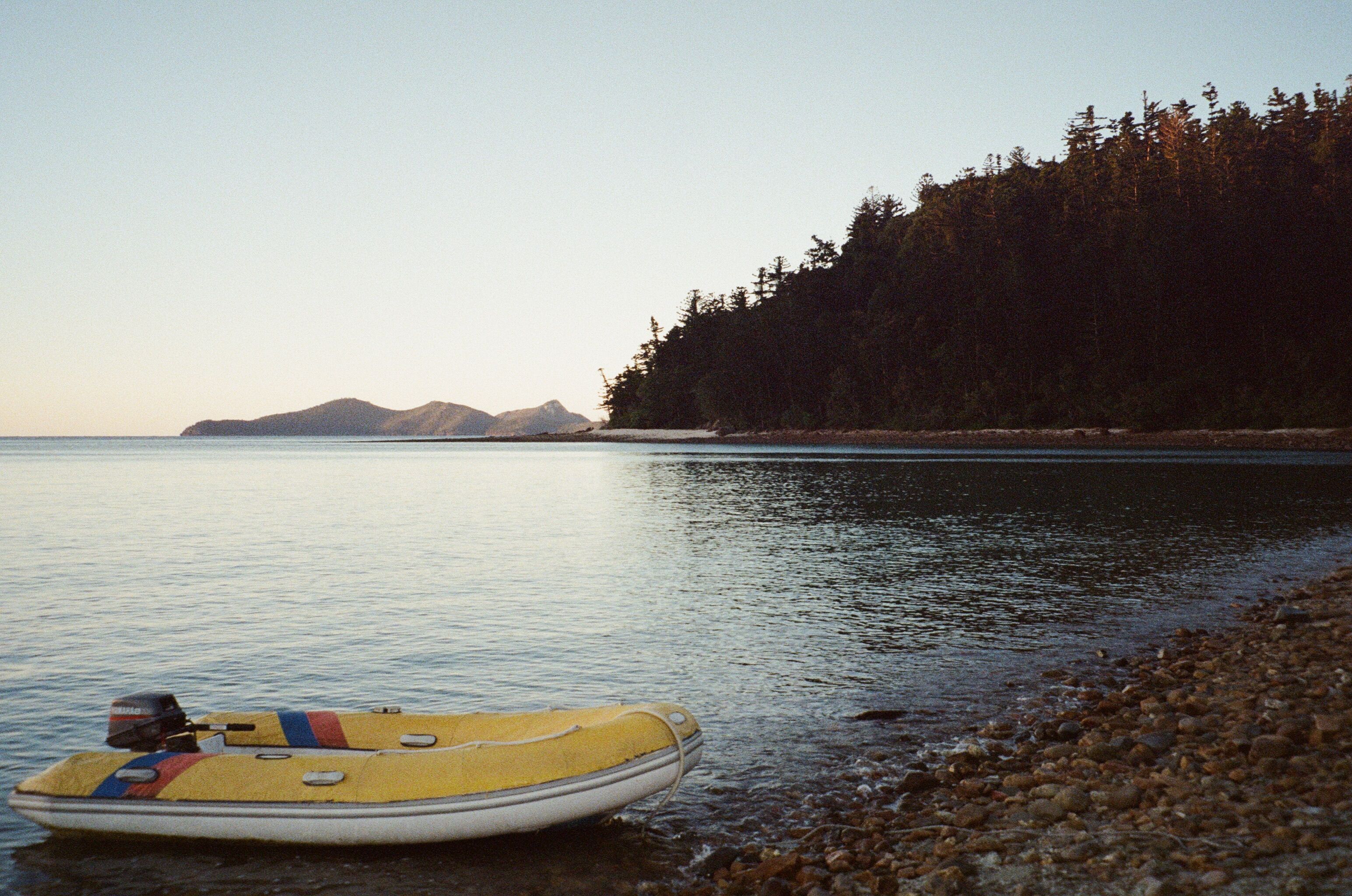 A yellow inflatable boat on the shore of a body of water · Free Stock Photo