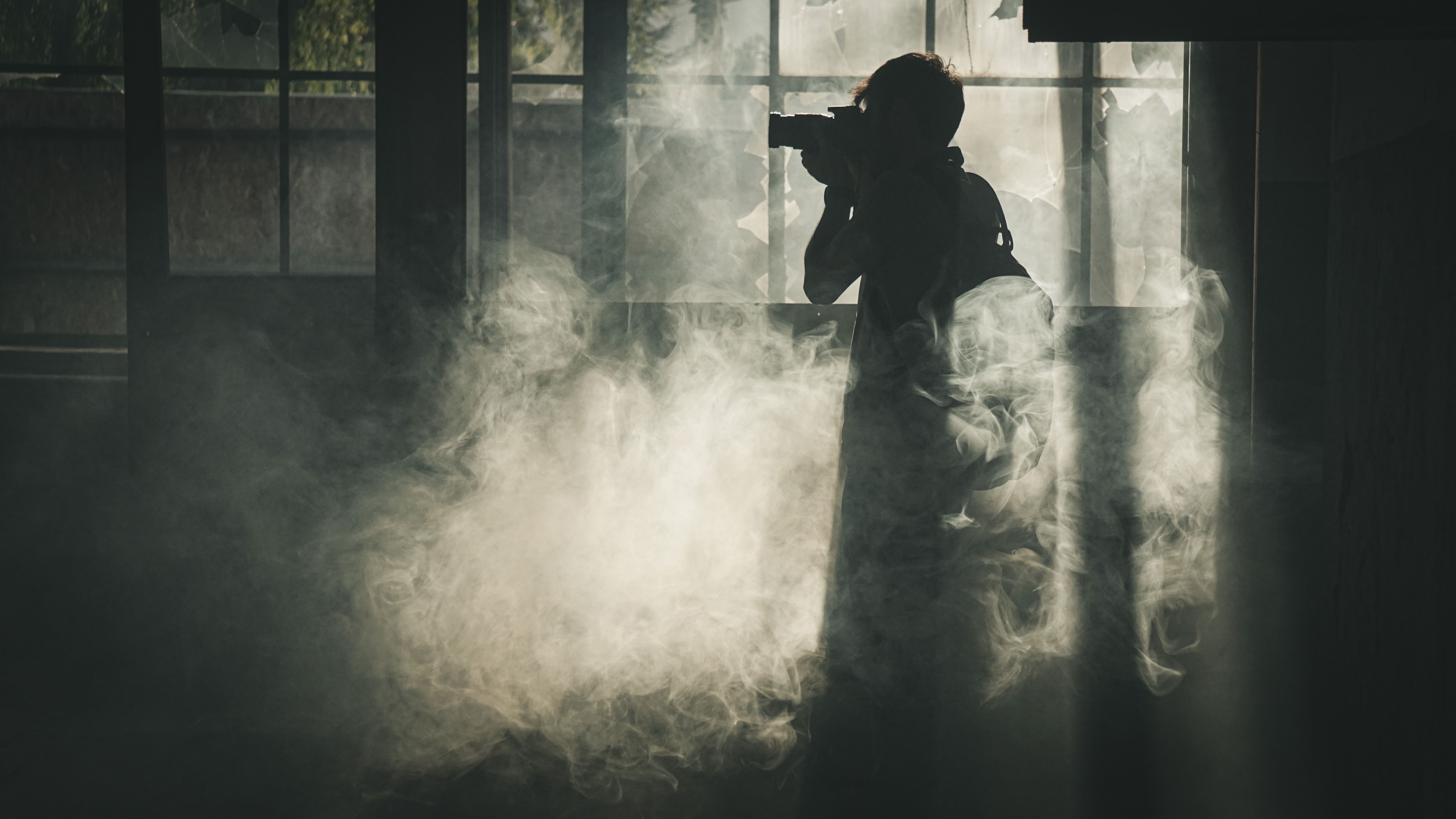 A man is standing in a room with smoke coming out of the window · Free ...