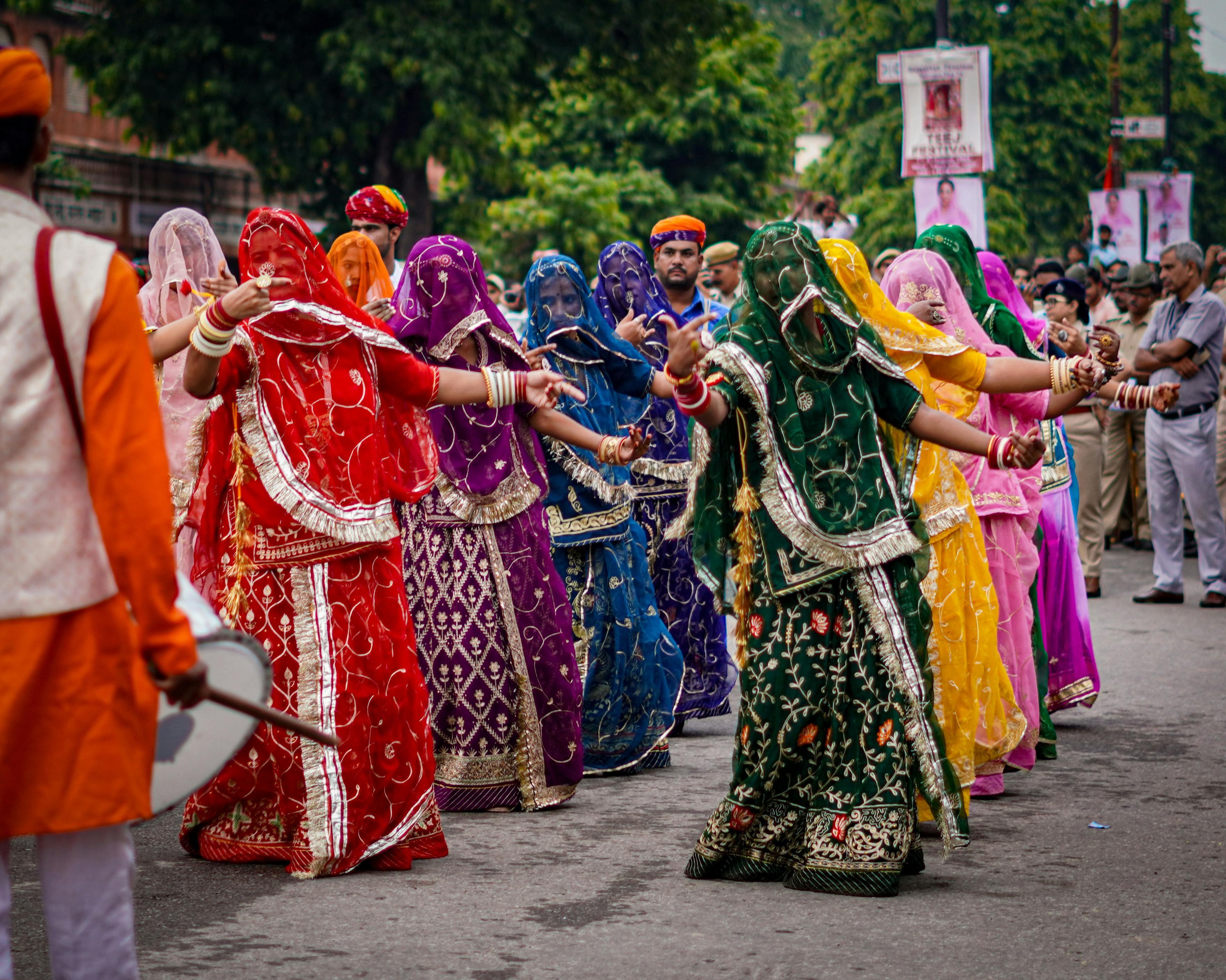 A group of women in colorful saris dancing in the street · Free Stock Photo
