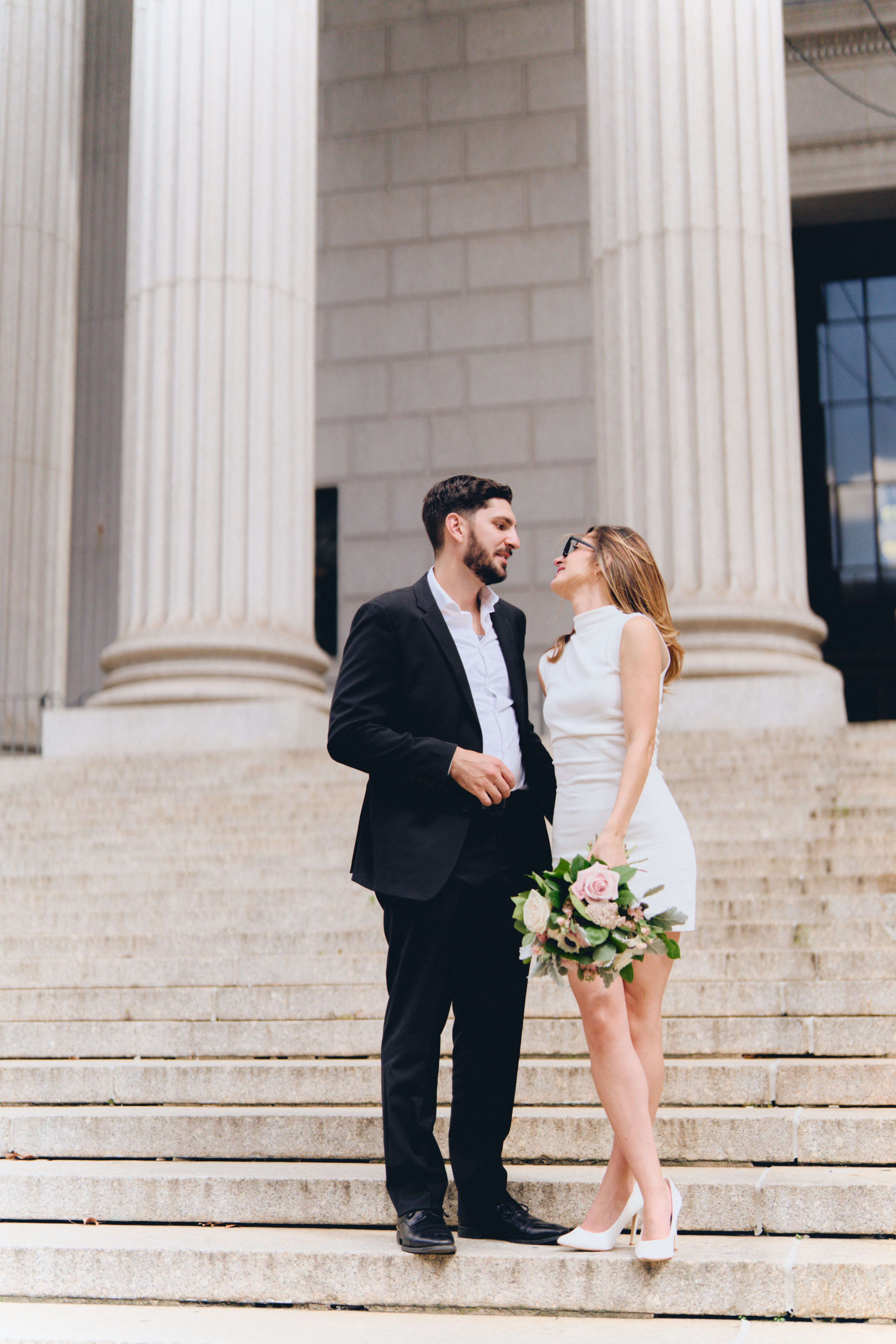 A bride and groom standing on the steps of a building · Free Stock Photo