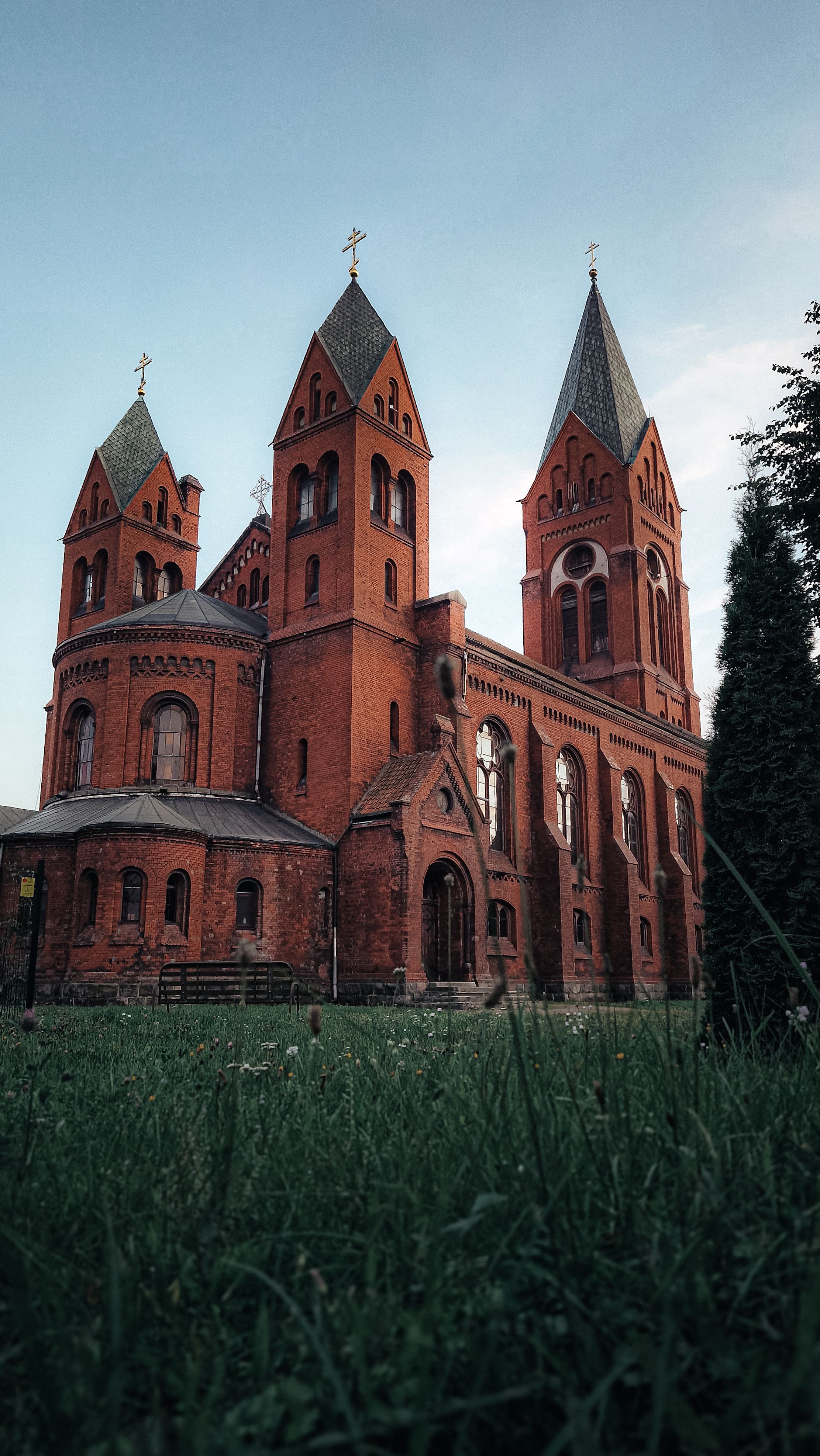 A large red brick church with two towers · Free Stock Photo