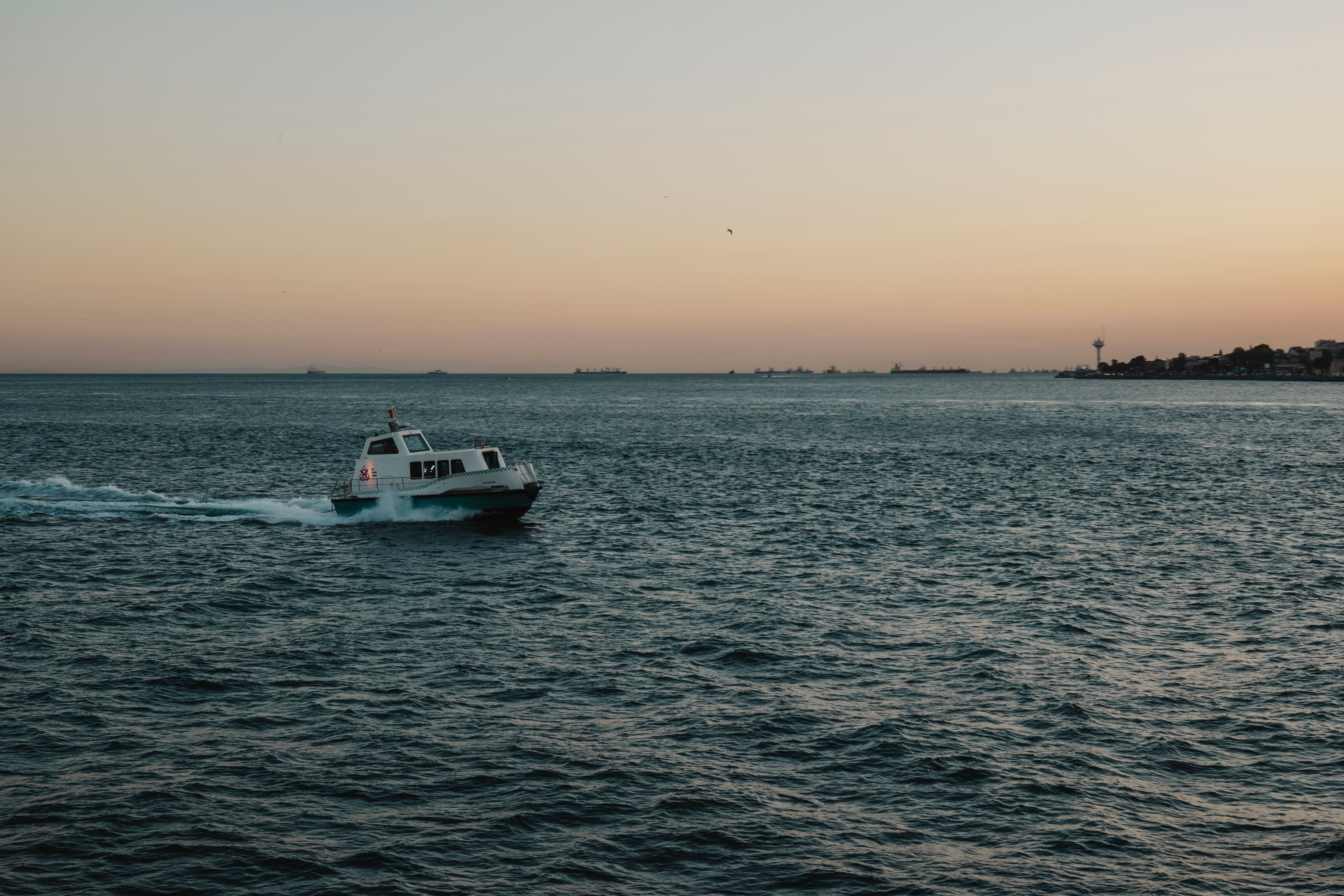 A boat traveling across the water at sunset · Free Stock Photo