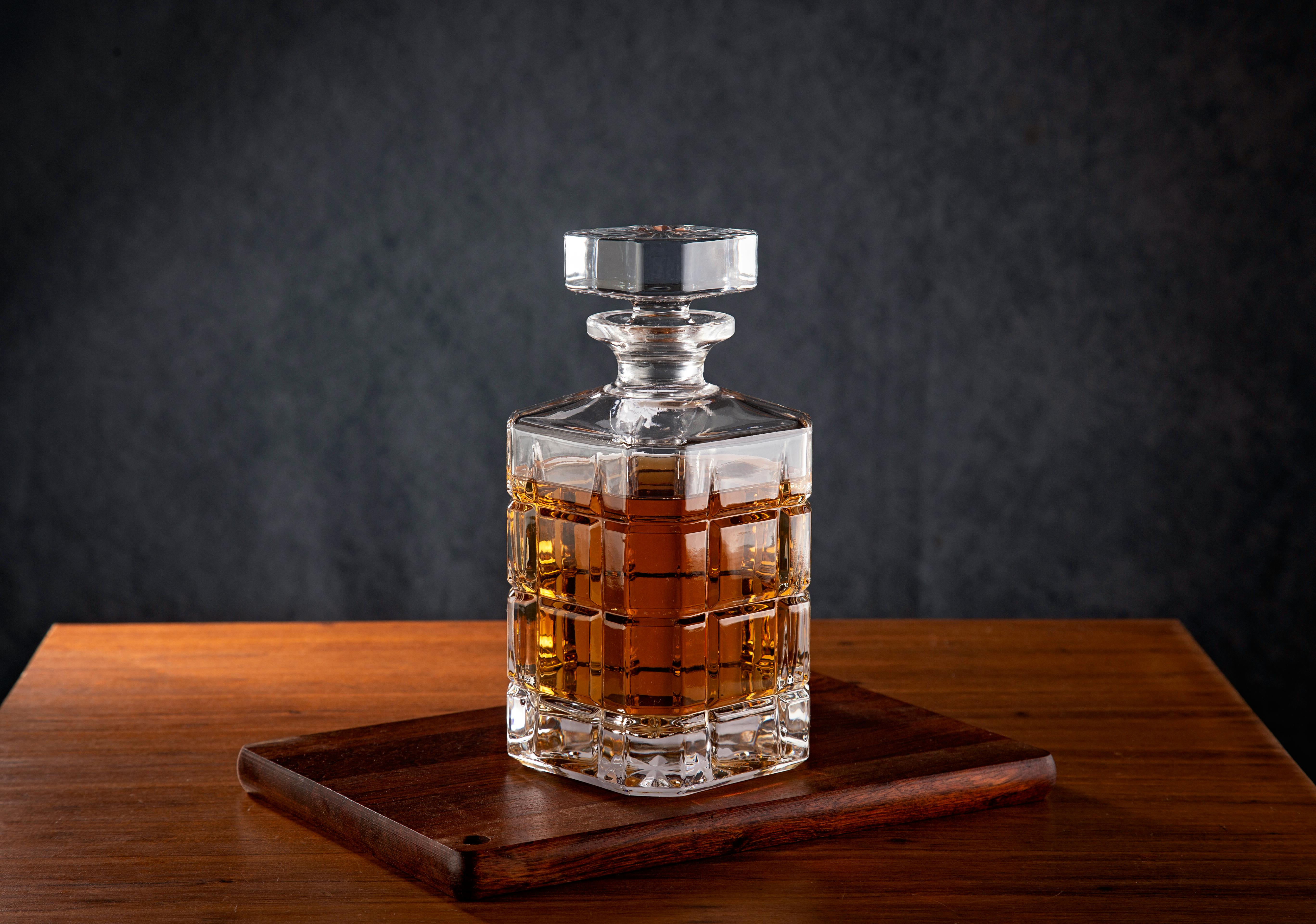 A whiskey decanter on a wooden table · Free Stock Photo