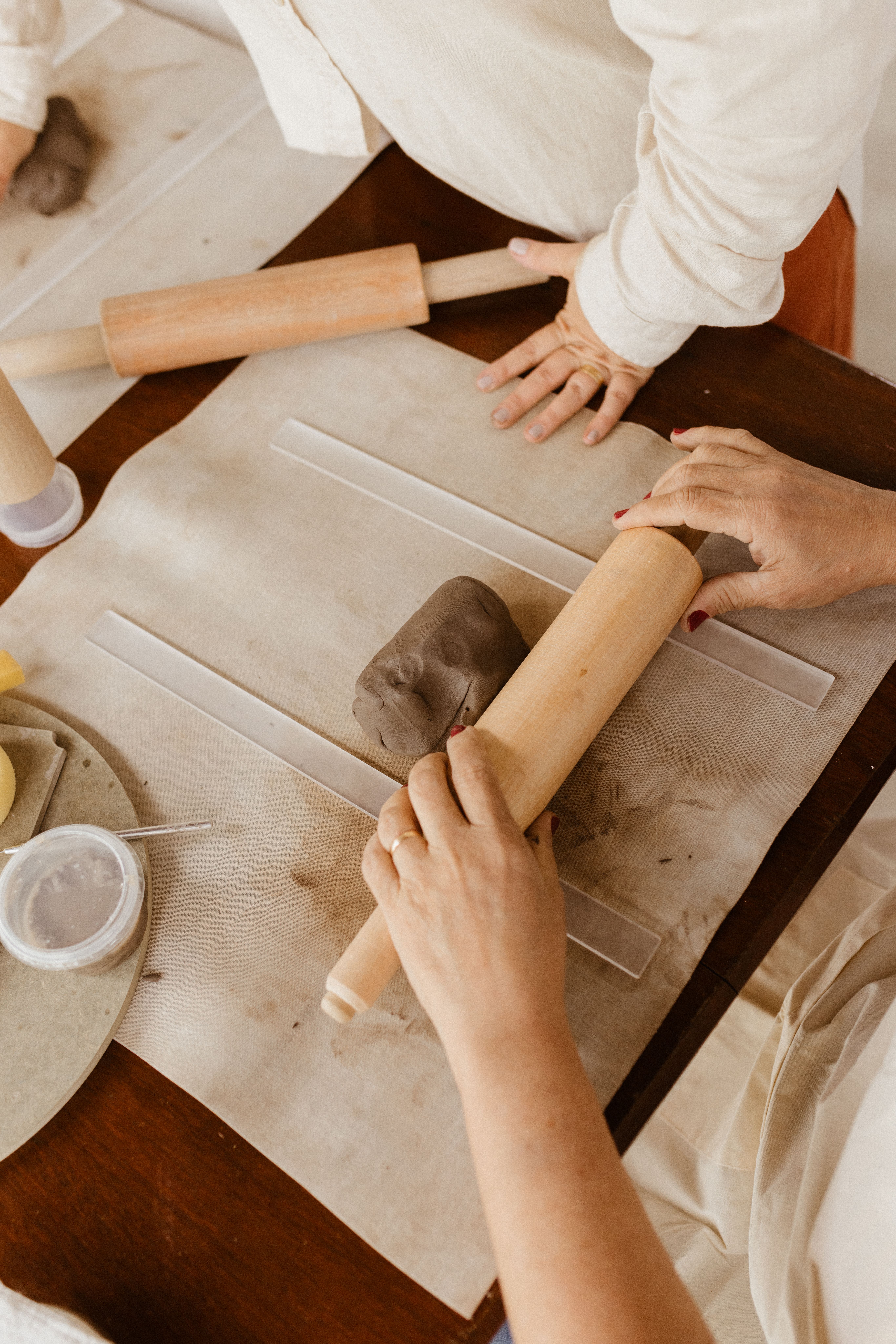 Two people making clay on a table · Free Stock Photo