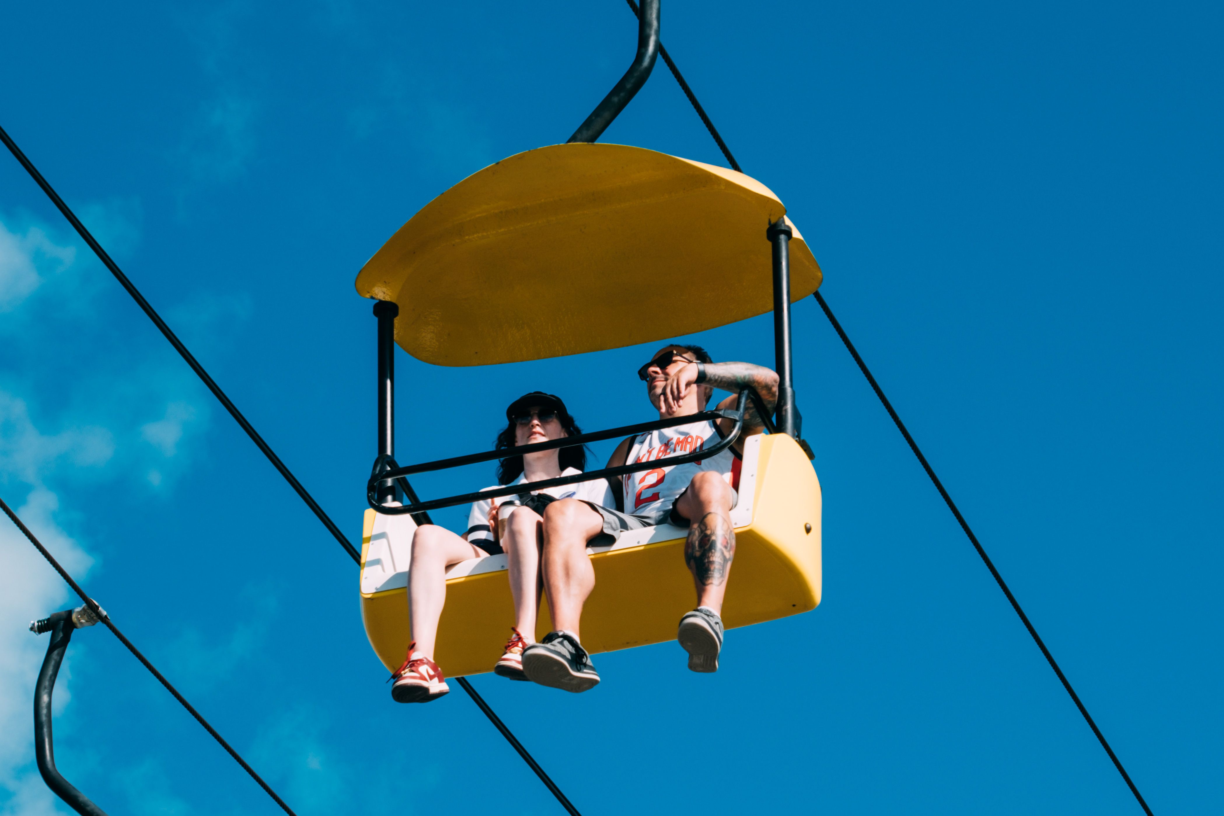 Two people riding a cable car in the sky · Free Stock Photo
