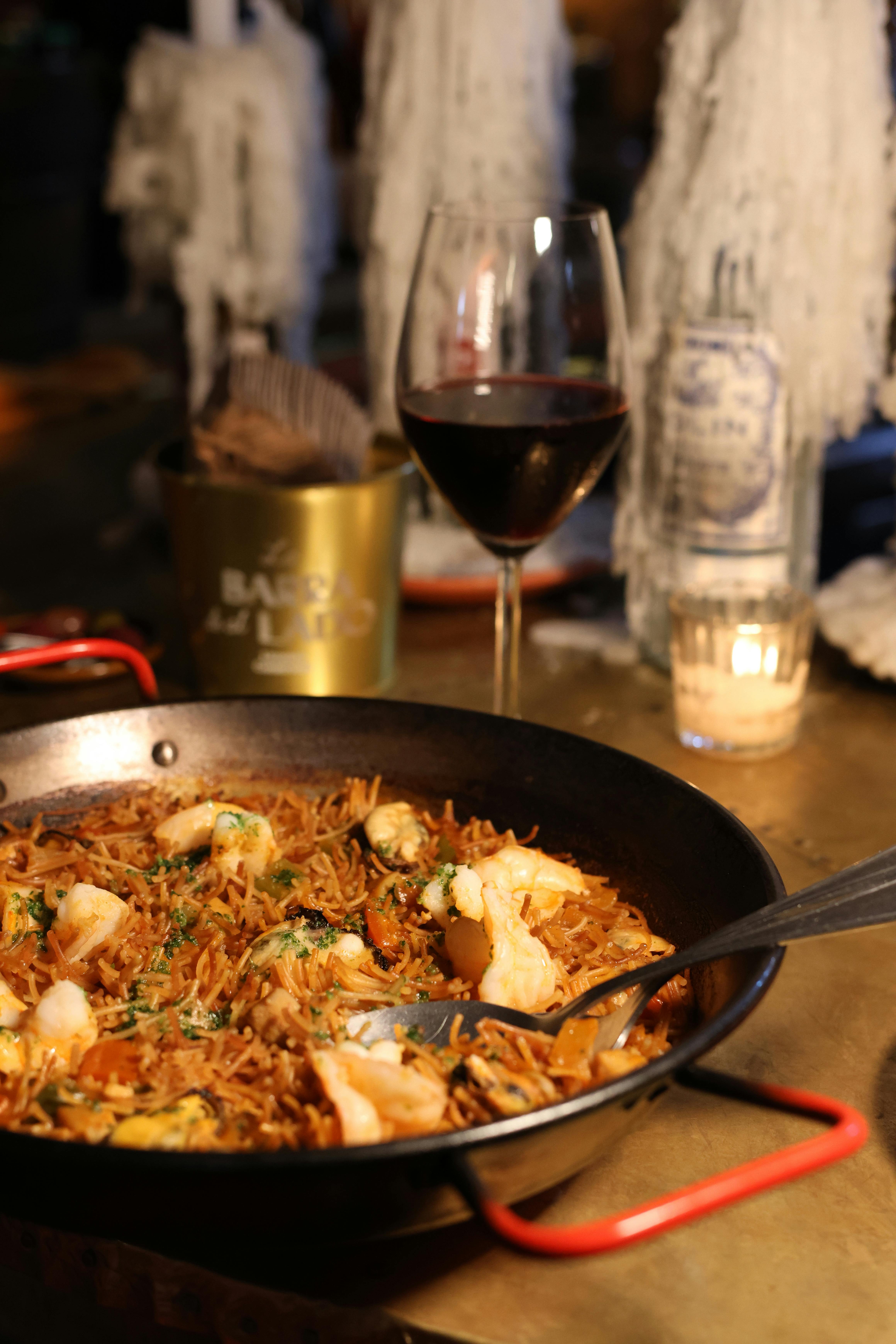 A pan filled with paella and wine · Free Stock Photo