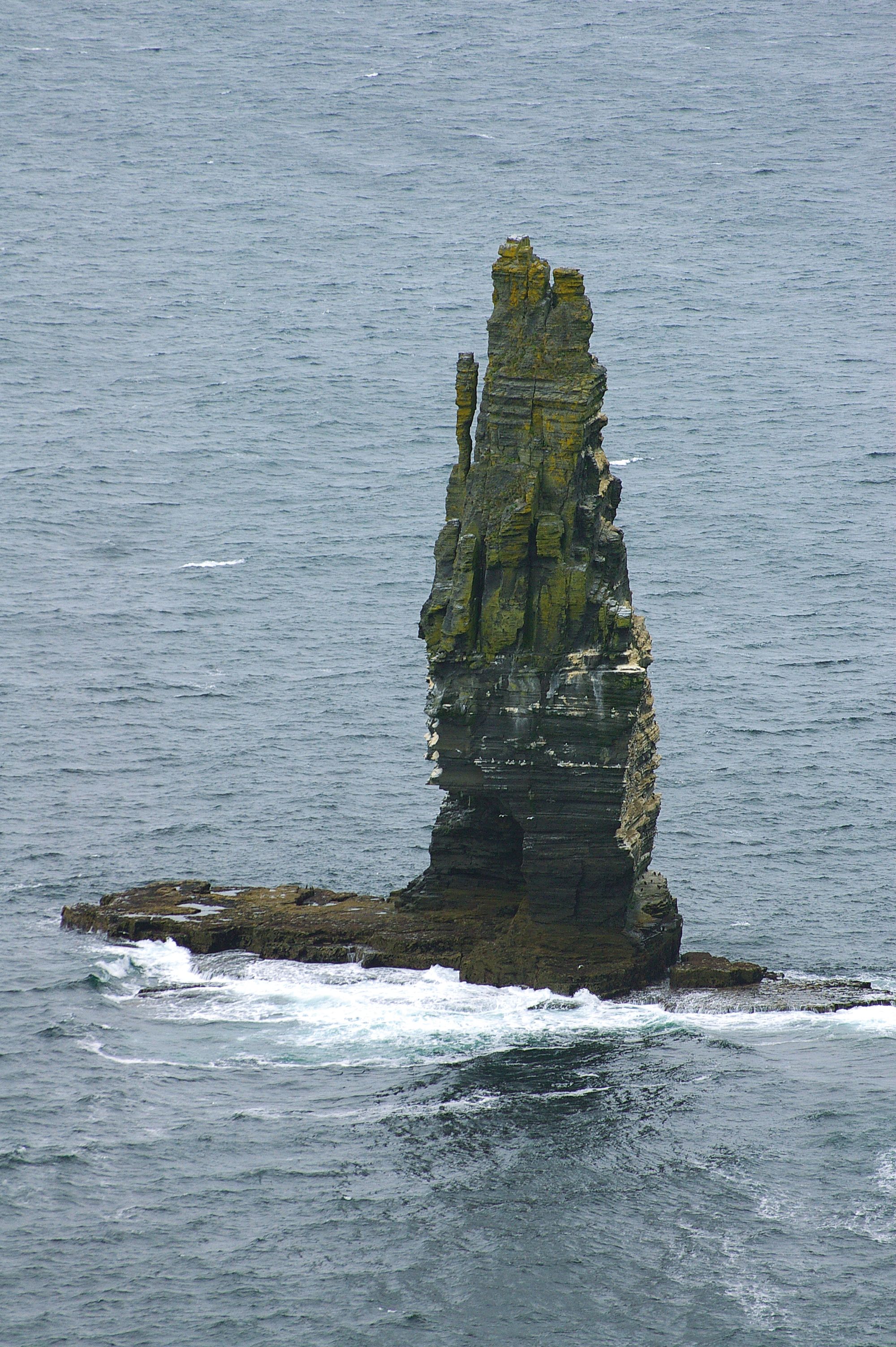 A tall rock formation in the ocean · Free Stock Photo
