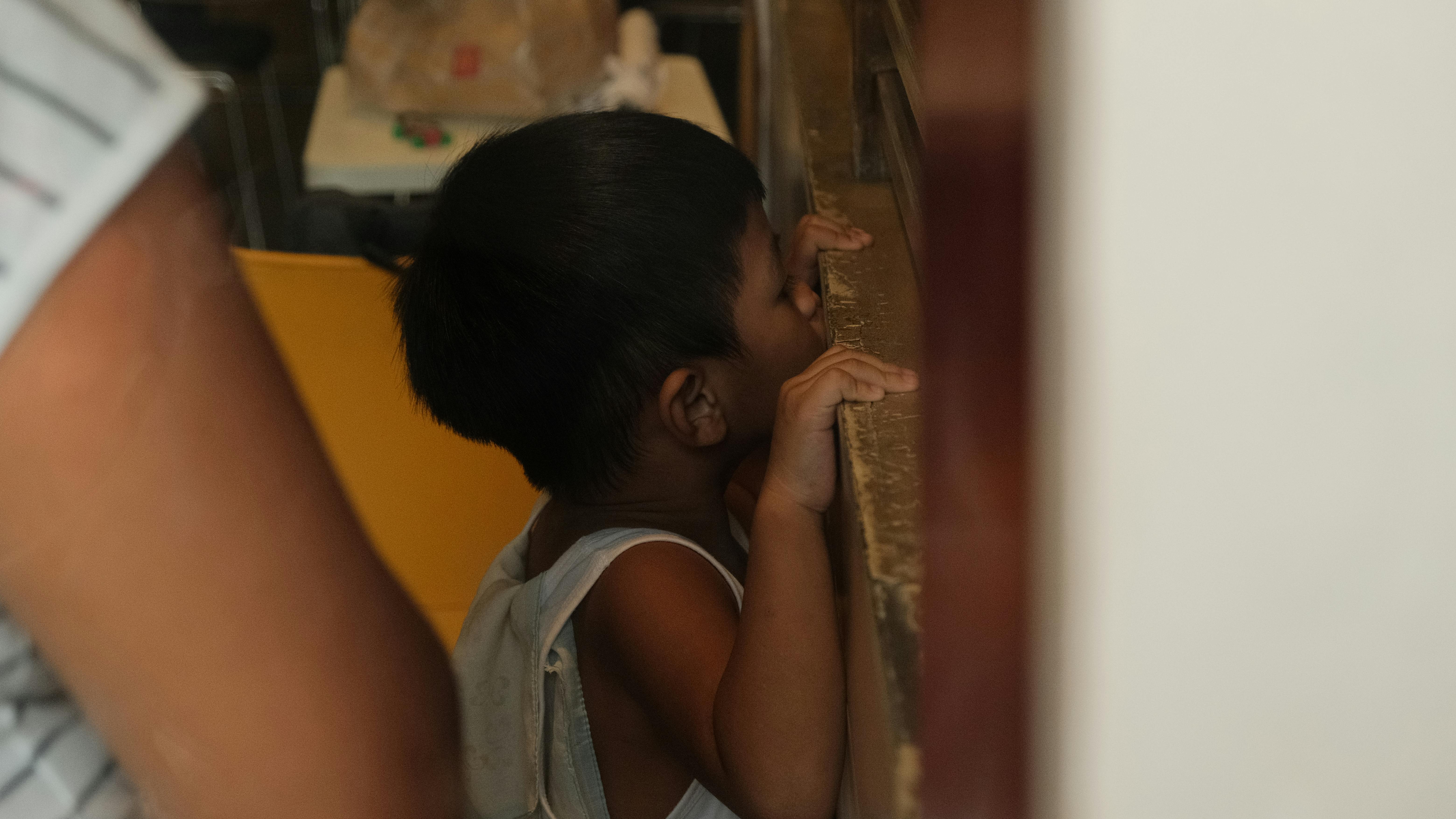 Curious Child Peering Out the Window in Manila · Free Stock Photo