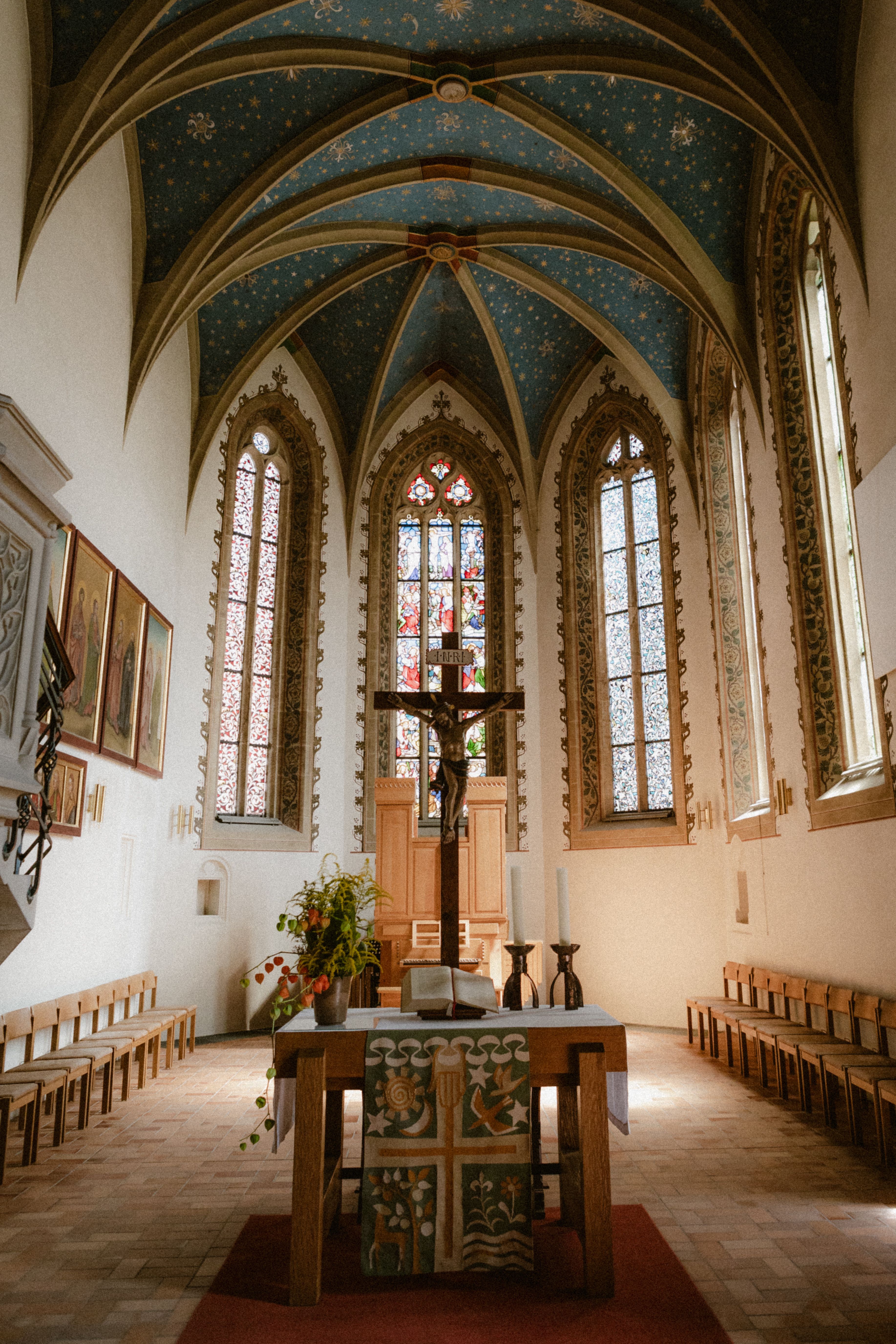 A church with a cross on the altar and a stained glass window · Free ...