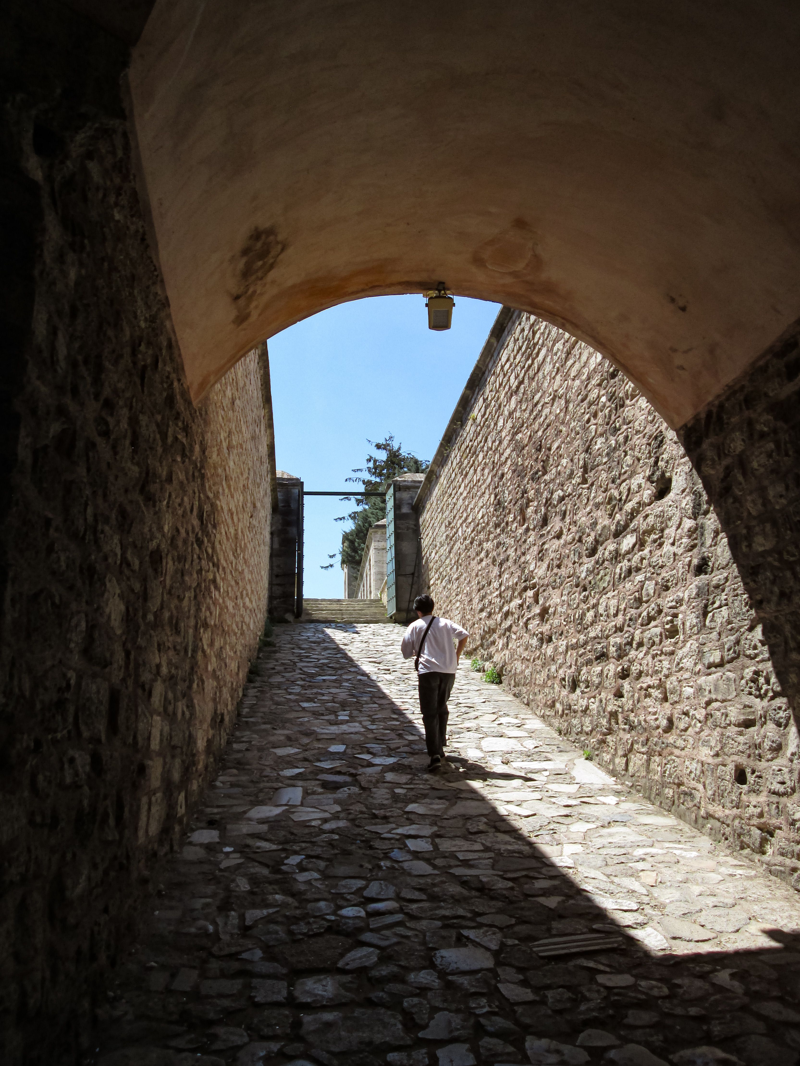 A man walking down a narrow alleyway · Free Stock Photo