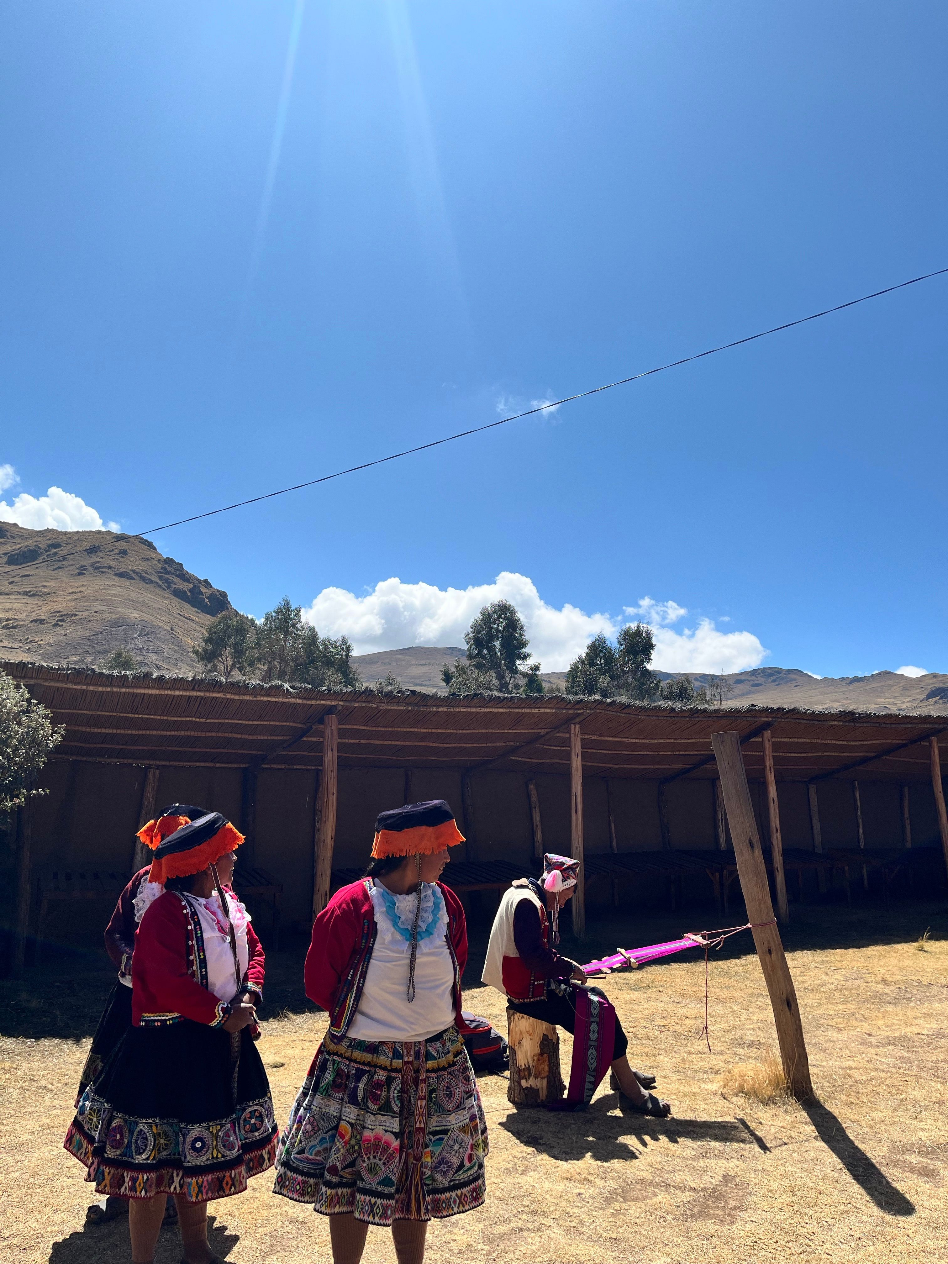 Women in traditional clothing stand in front of a hut · Free Stock Photo