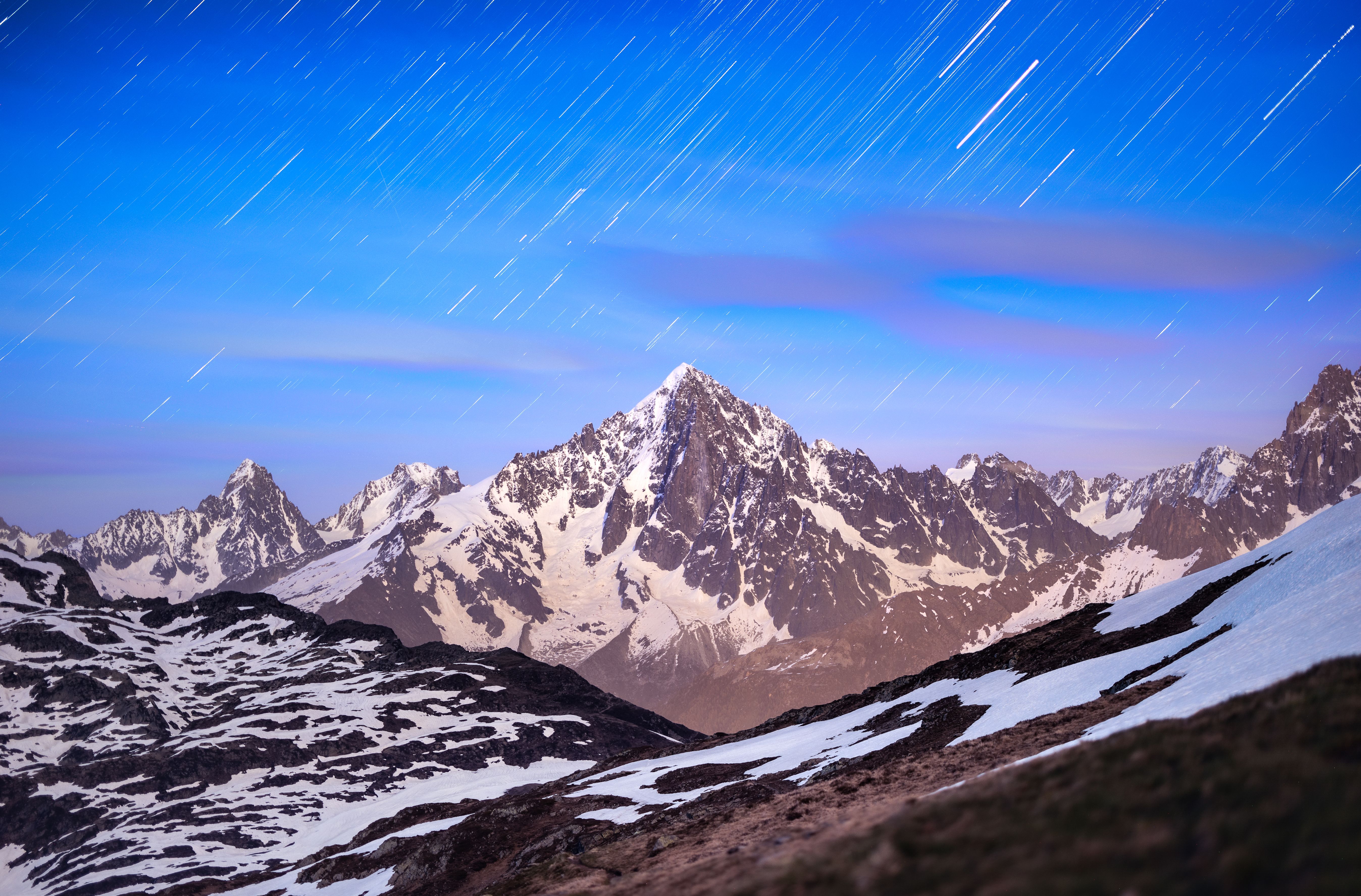 A long exposure photograph of snow covered mountains · Free Stock Photo