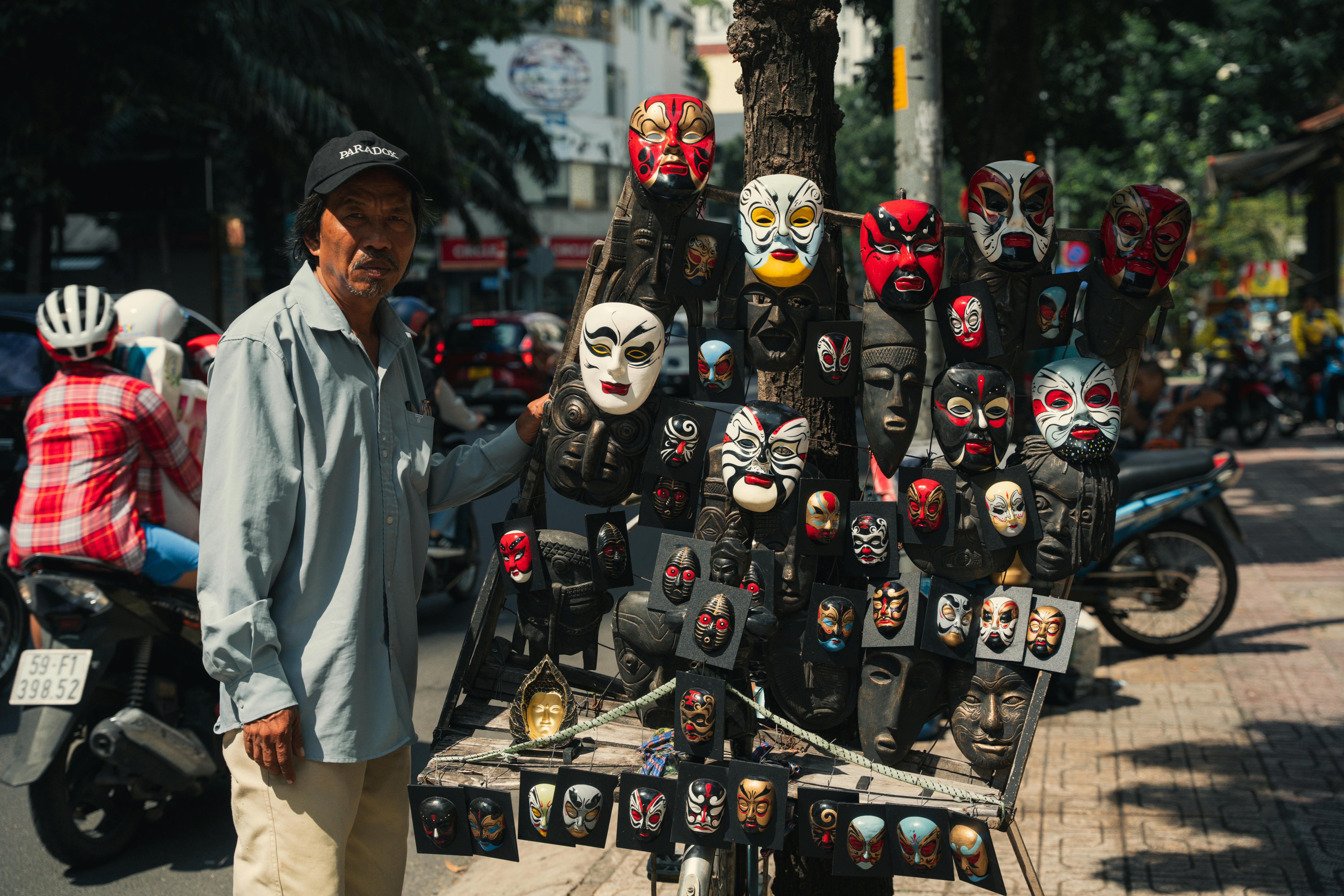 Street Vendor Displaying Traditional Masks in City · Free Stock Photo