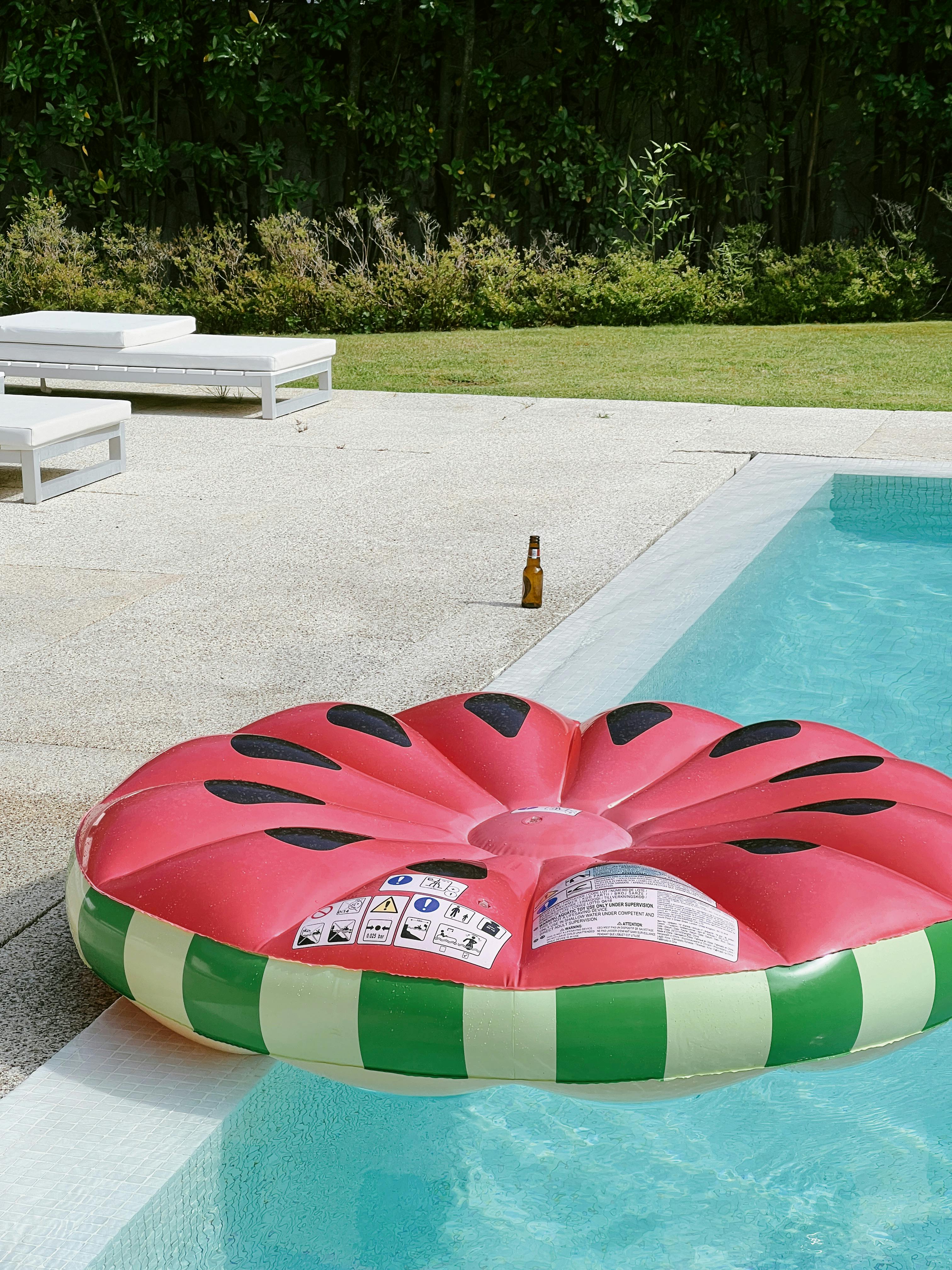 A watermelon inflatable pool float with a bottle of beer · Free Stock Photo