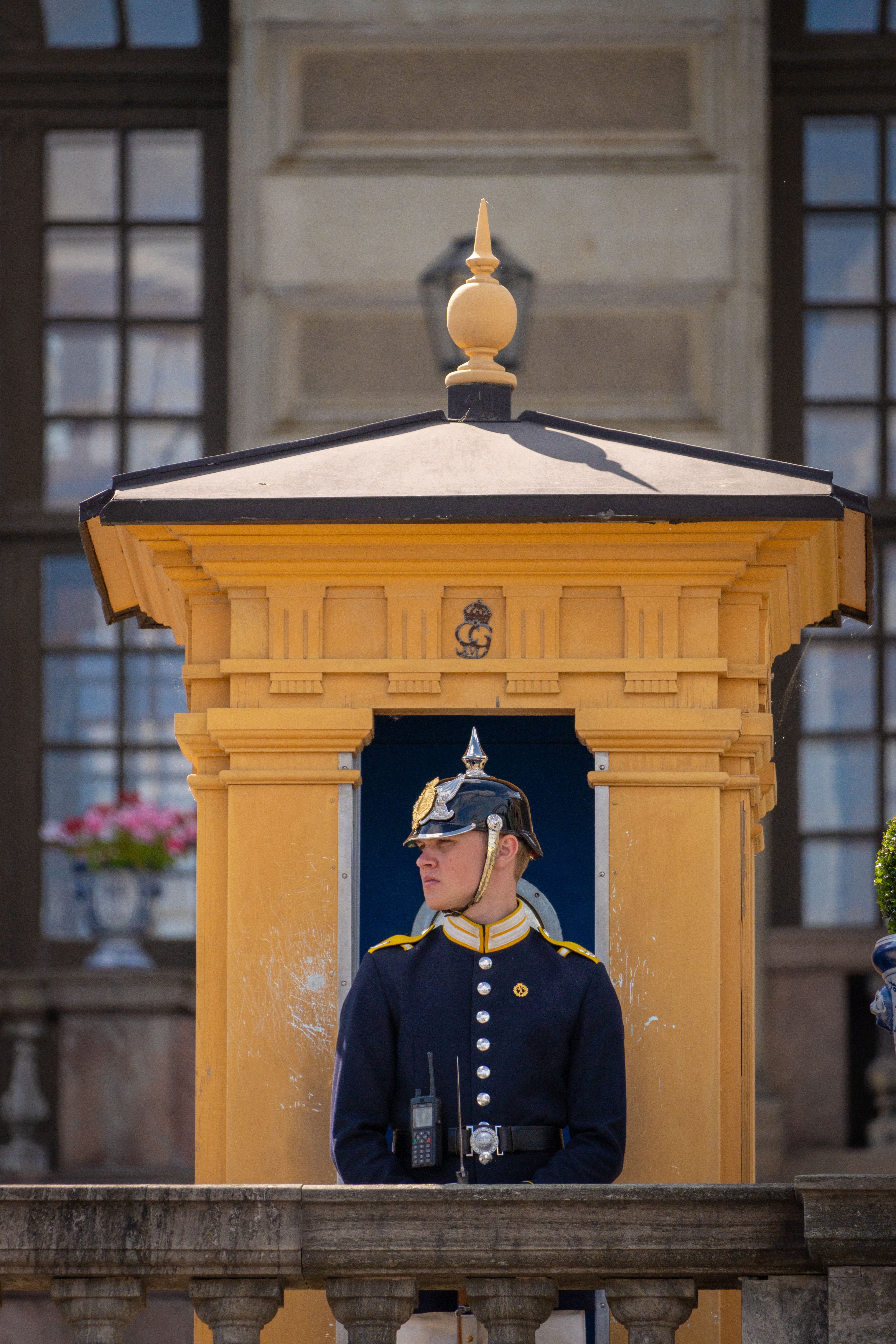 A man in uniform stands guard at the entrance to a building · Free ...