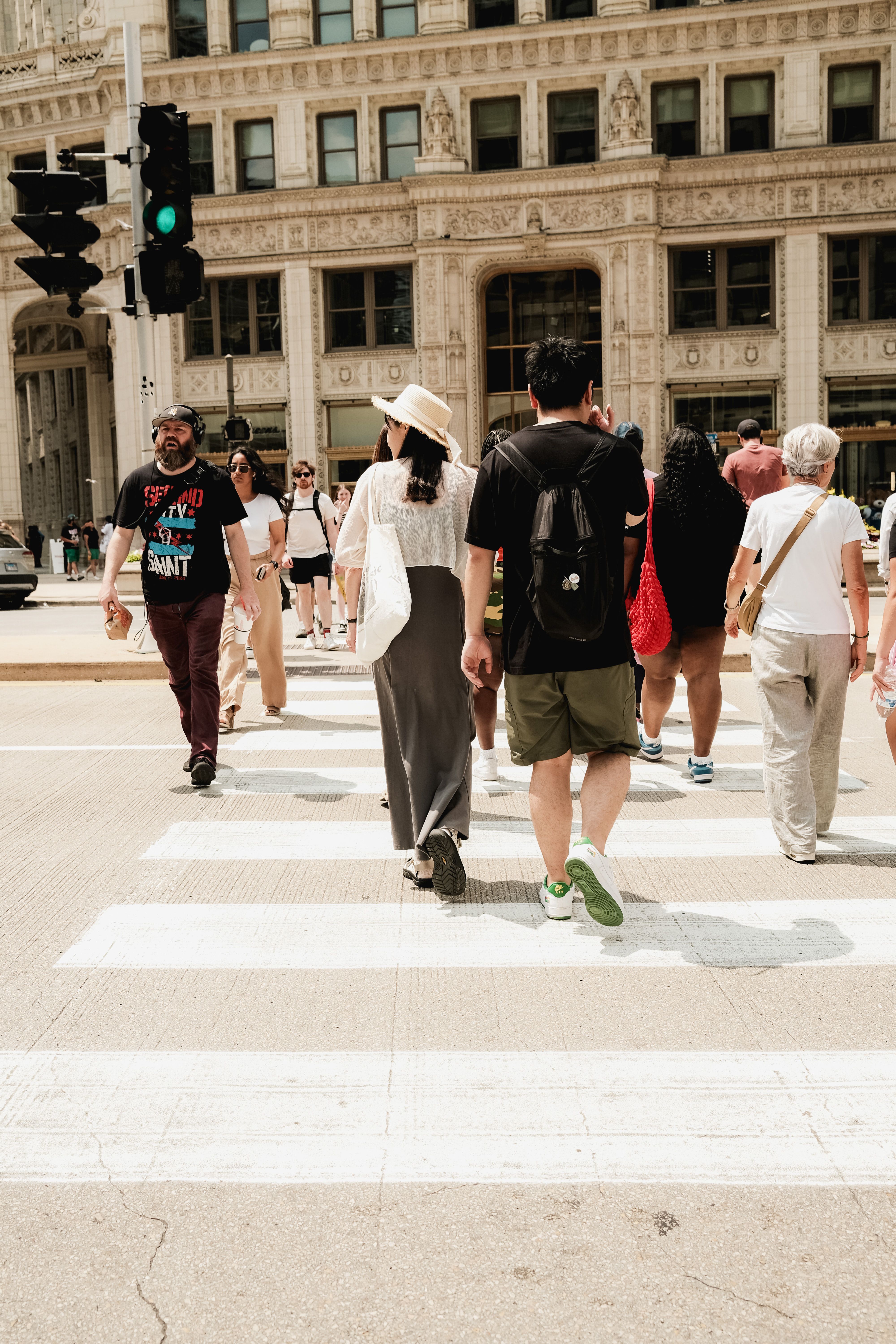 People walking across a crosswalk in a city · Free Stock Photo