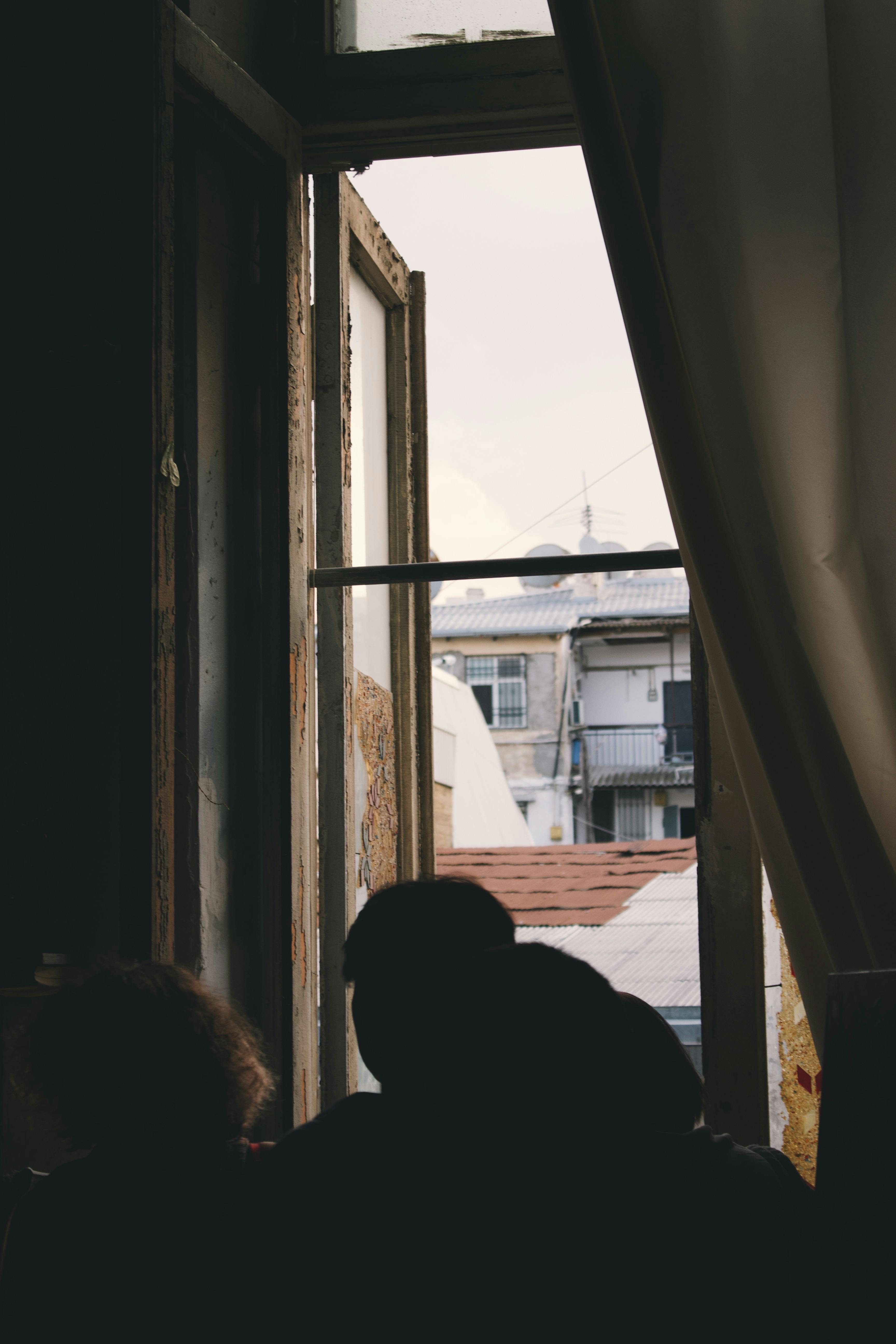 A couple sitting in front of a window · Free Stock Photo