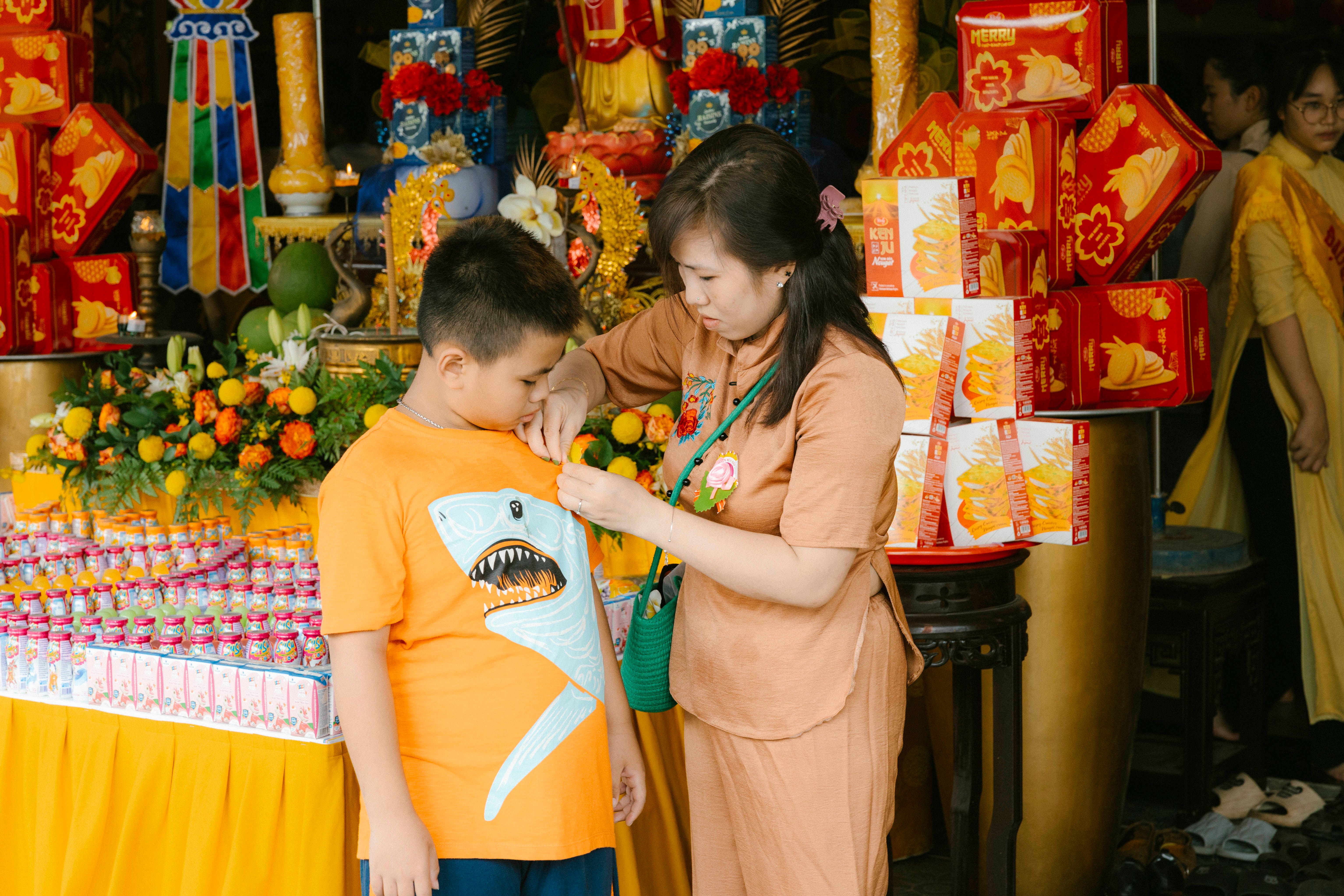 A woman is helping a child with a flower · Free Stock Photo