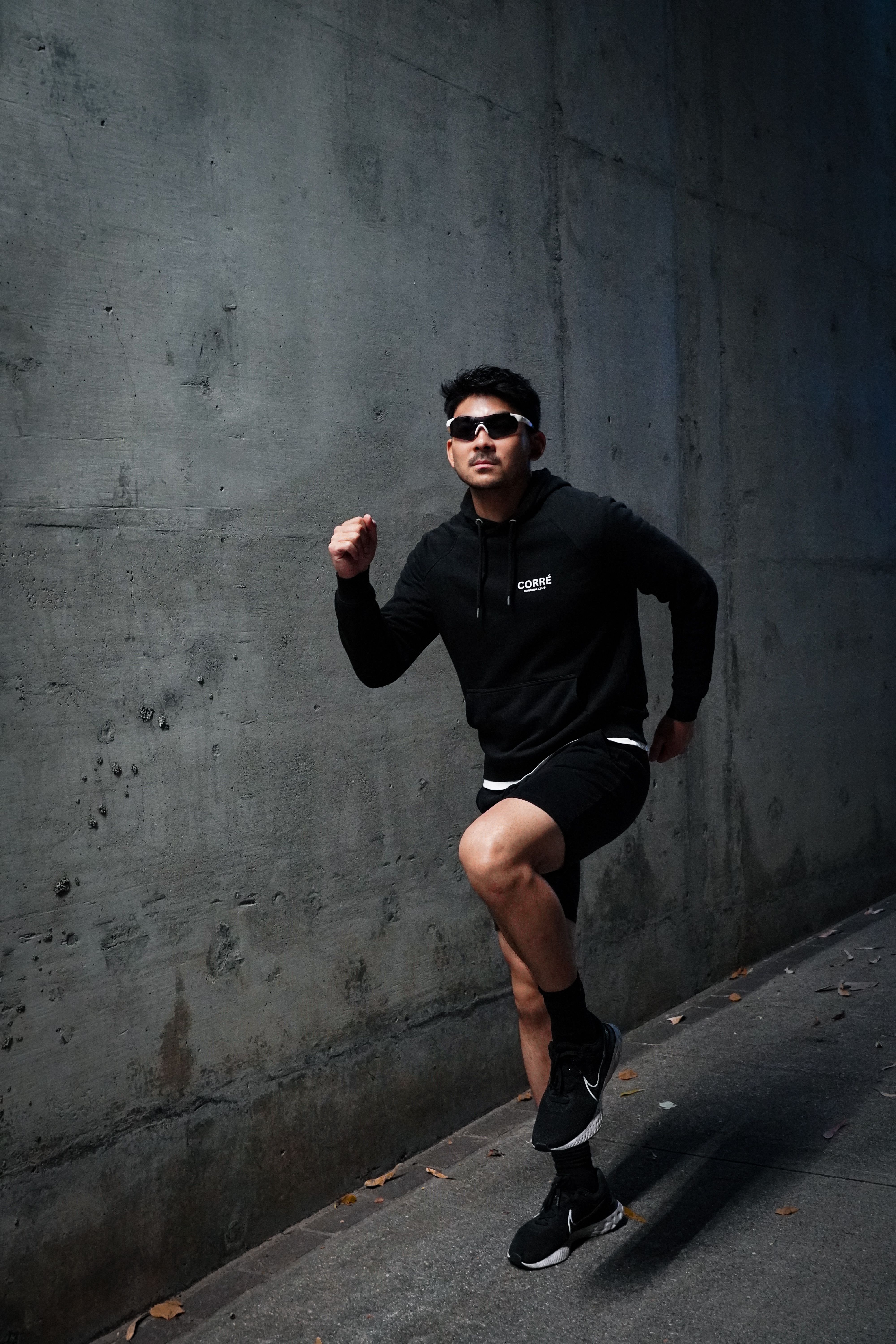 A man in black shorts and a black hoodie running · Free Stock Photo