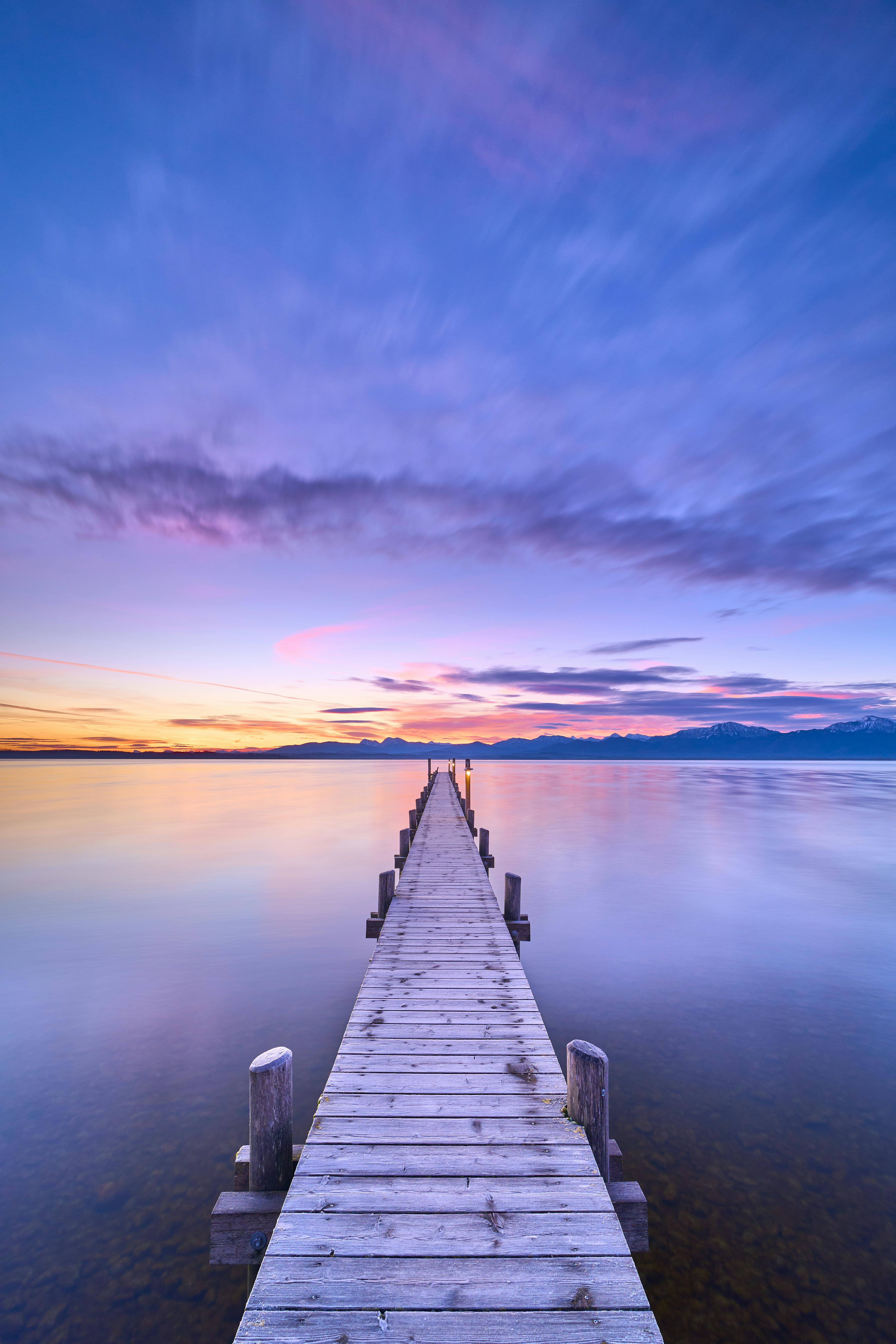 A long wooden pier with a beautiful sunset · Free Stock Photo