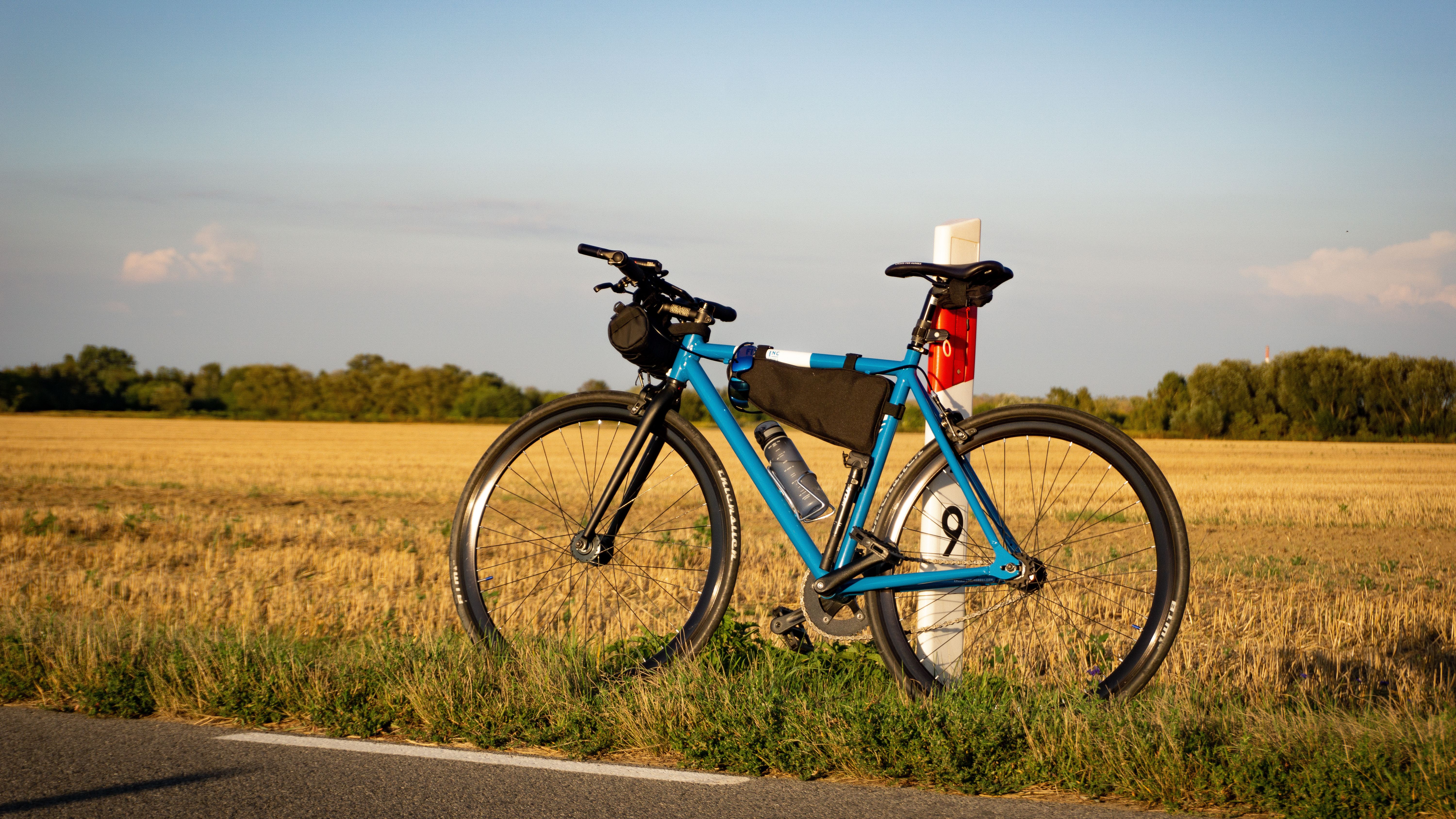 A blue bike is parked on the side of the road · Free Stock Photo