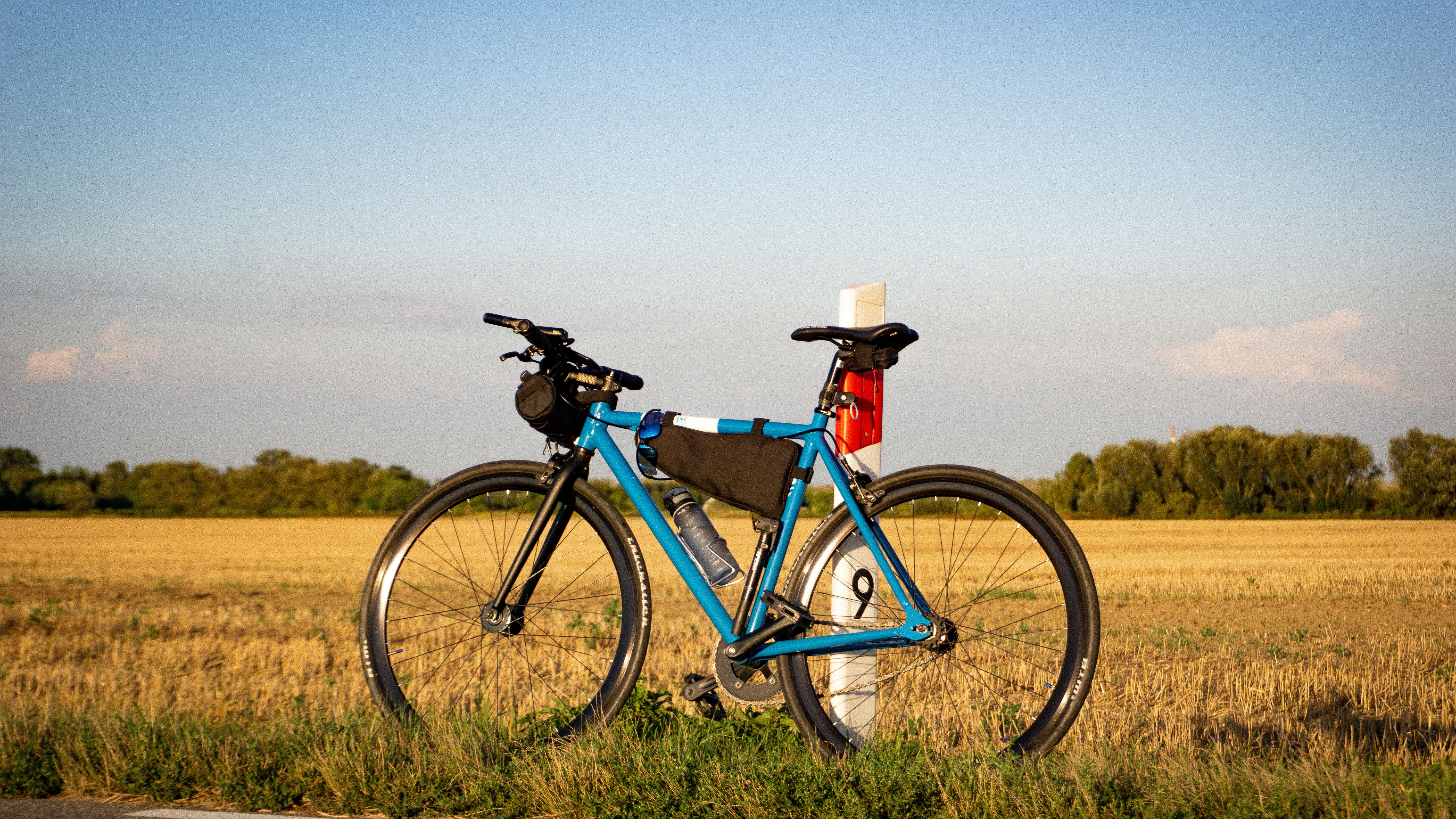 A blue bike parked on the side of a road · Free Stock Photo
