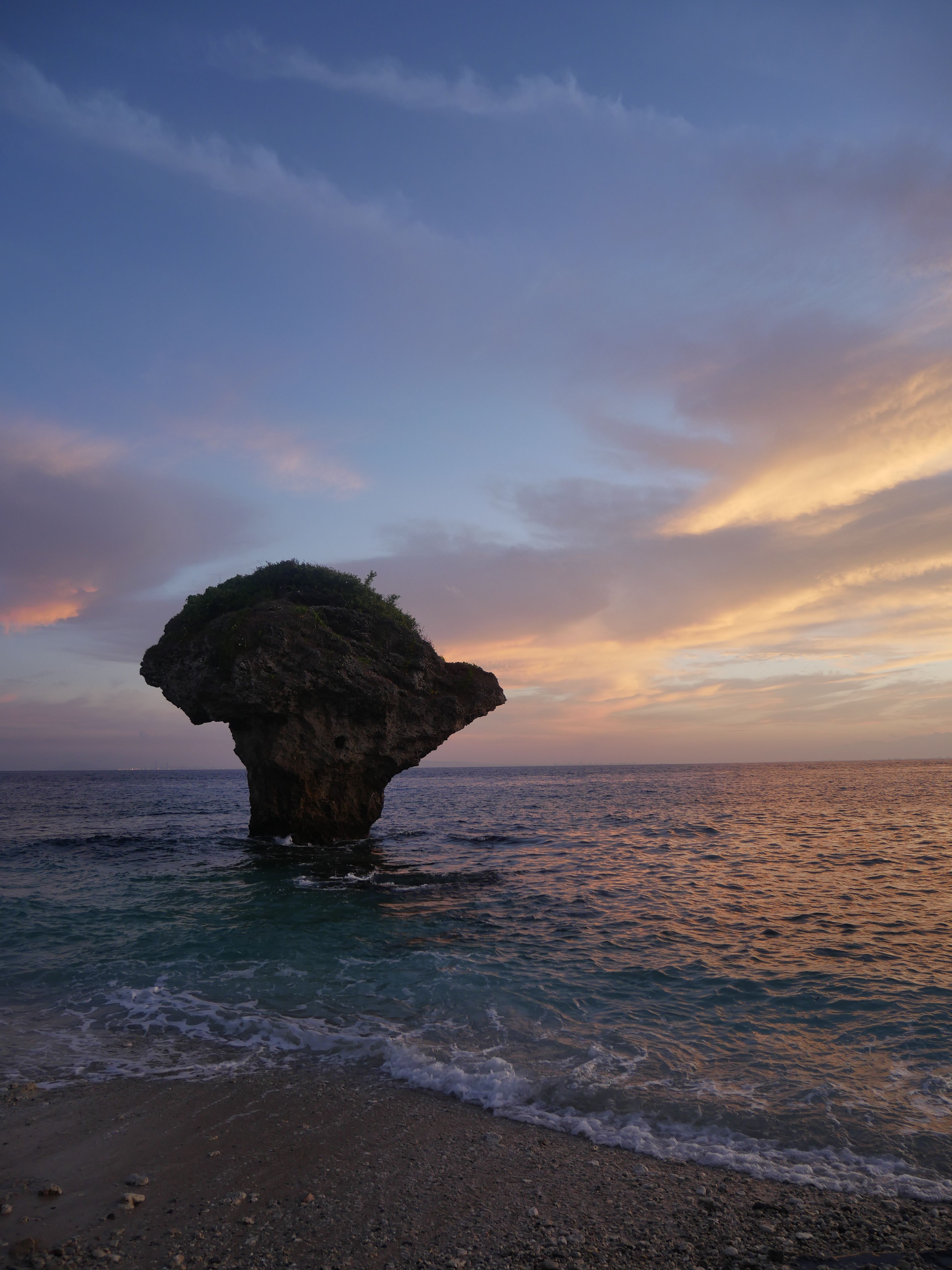 A rock formation on the beach at sunset · Free Stock Photo