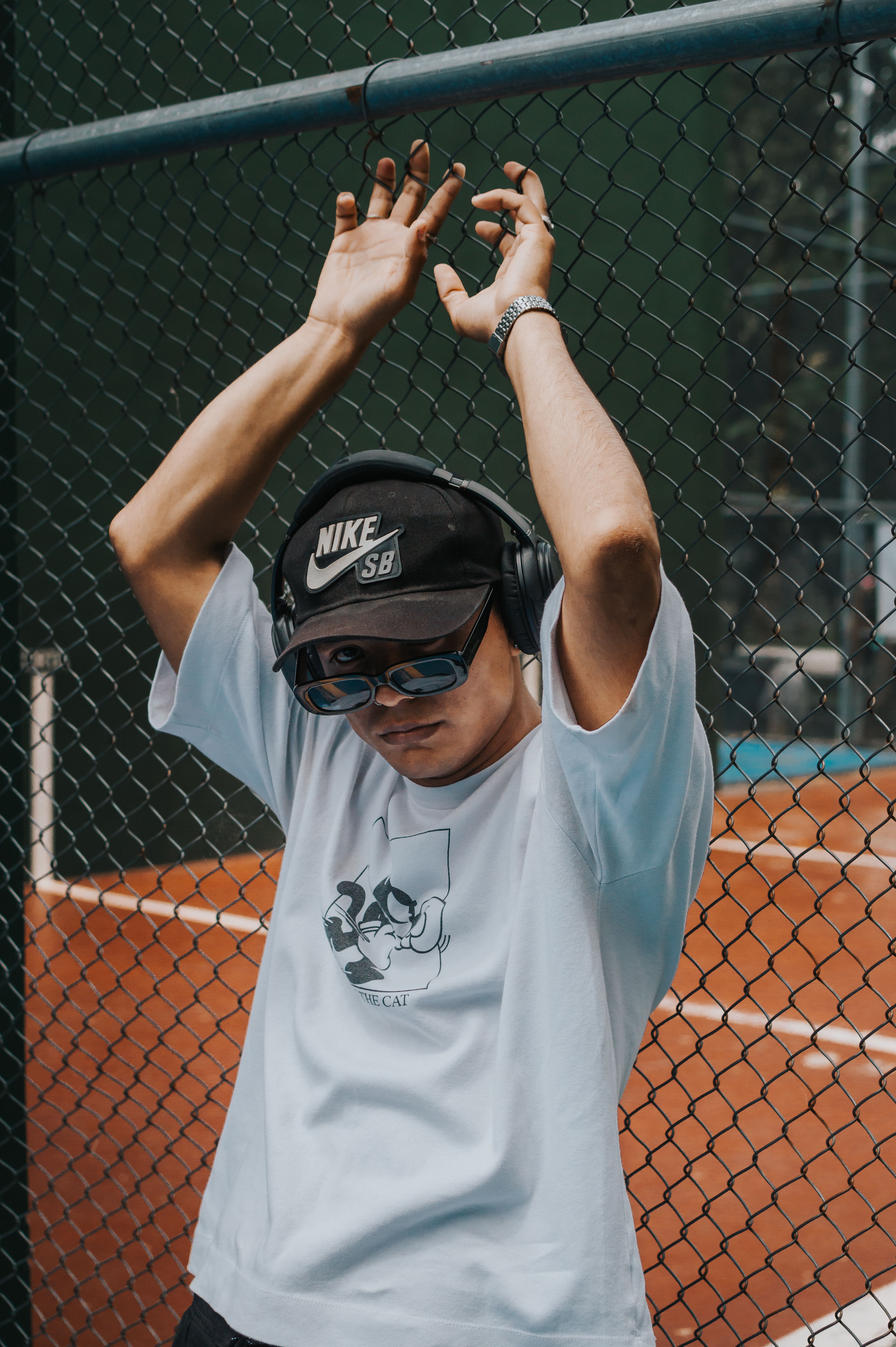 A man in a baseball cap and sunglasses is holding his hands up · Free ...