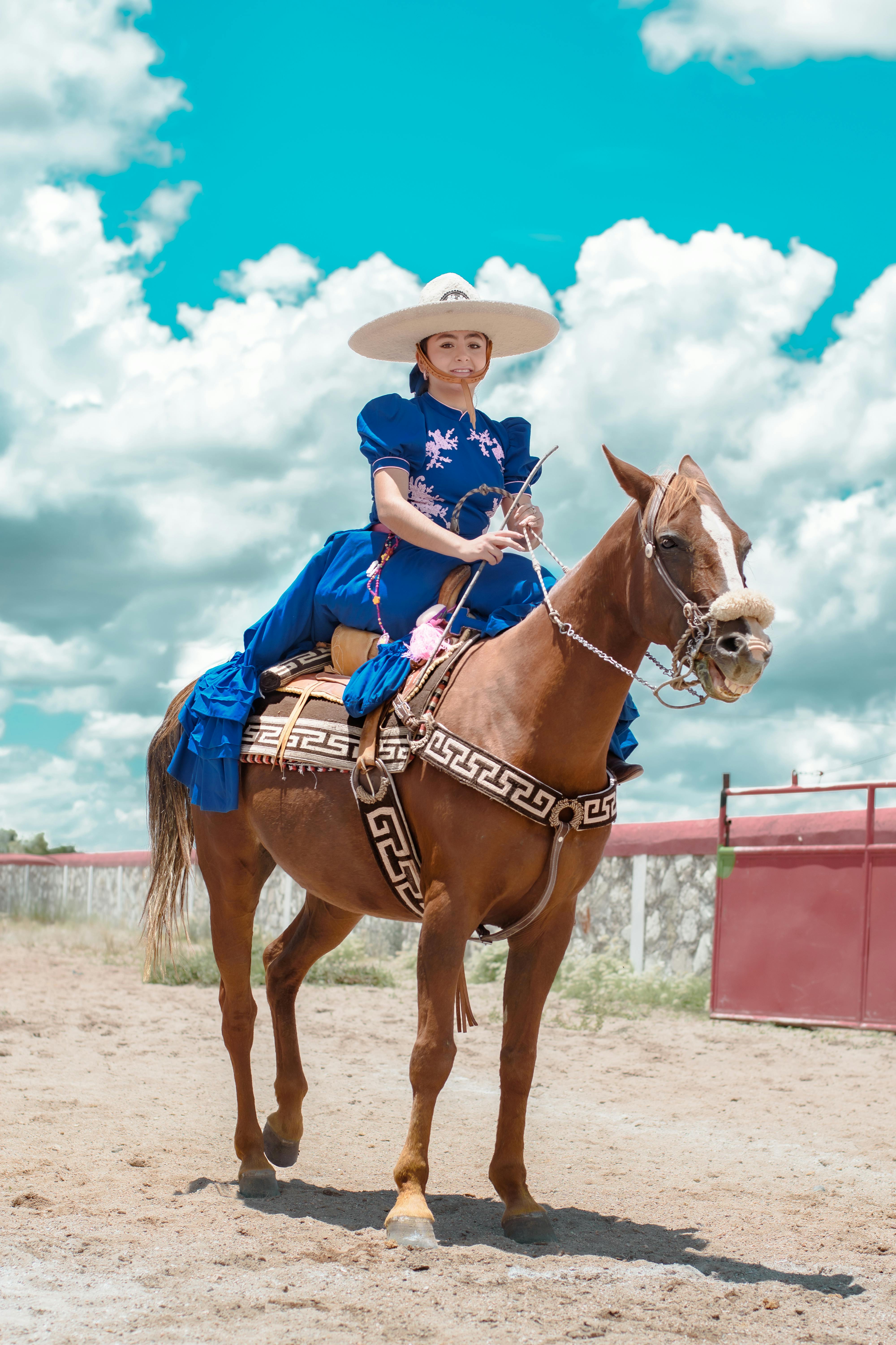 A girl in a blue dress riding a horse · Free Stock Photo