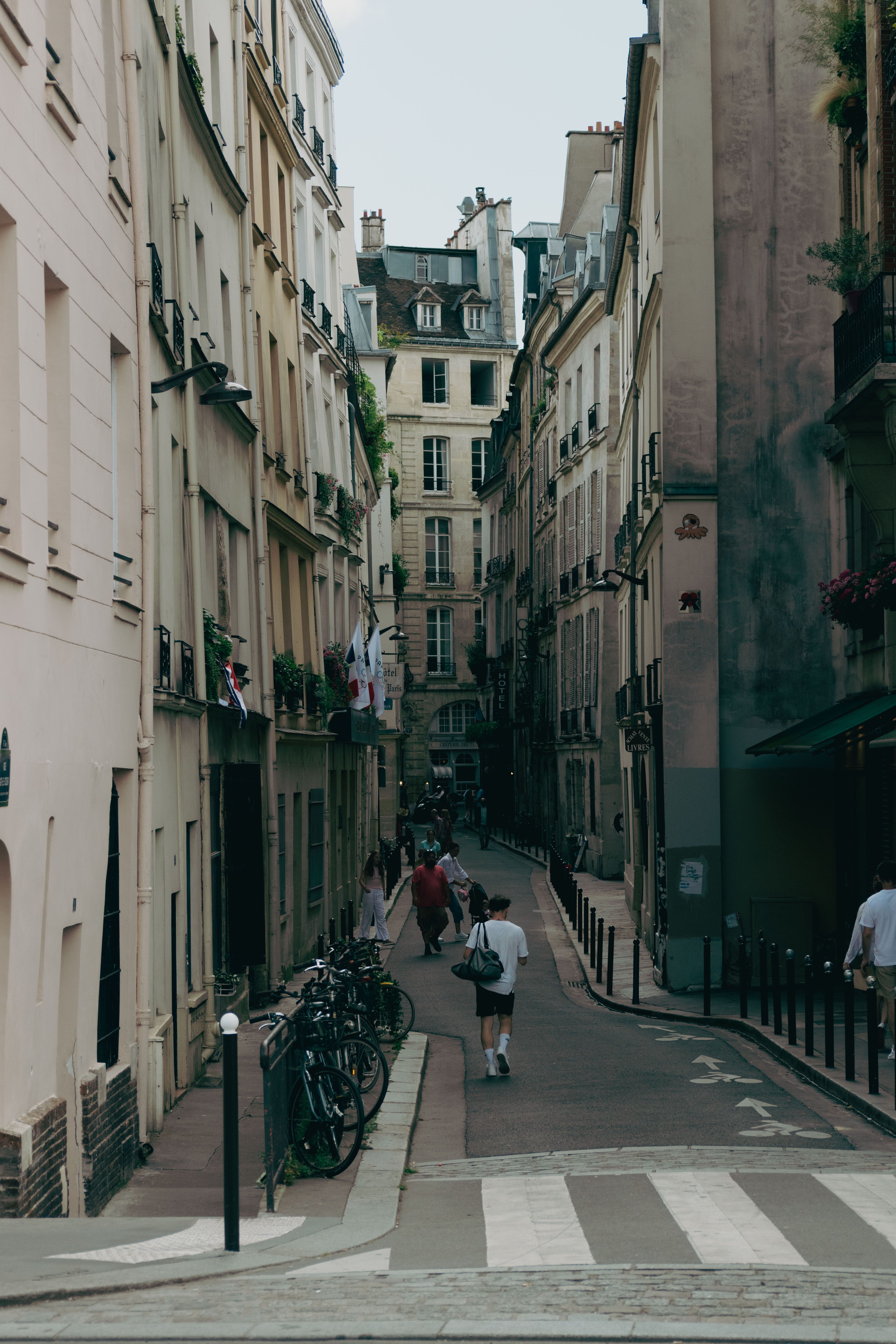 A narrow street with people walking down it · Free Stock Photo