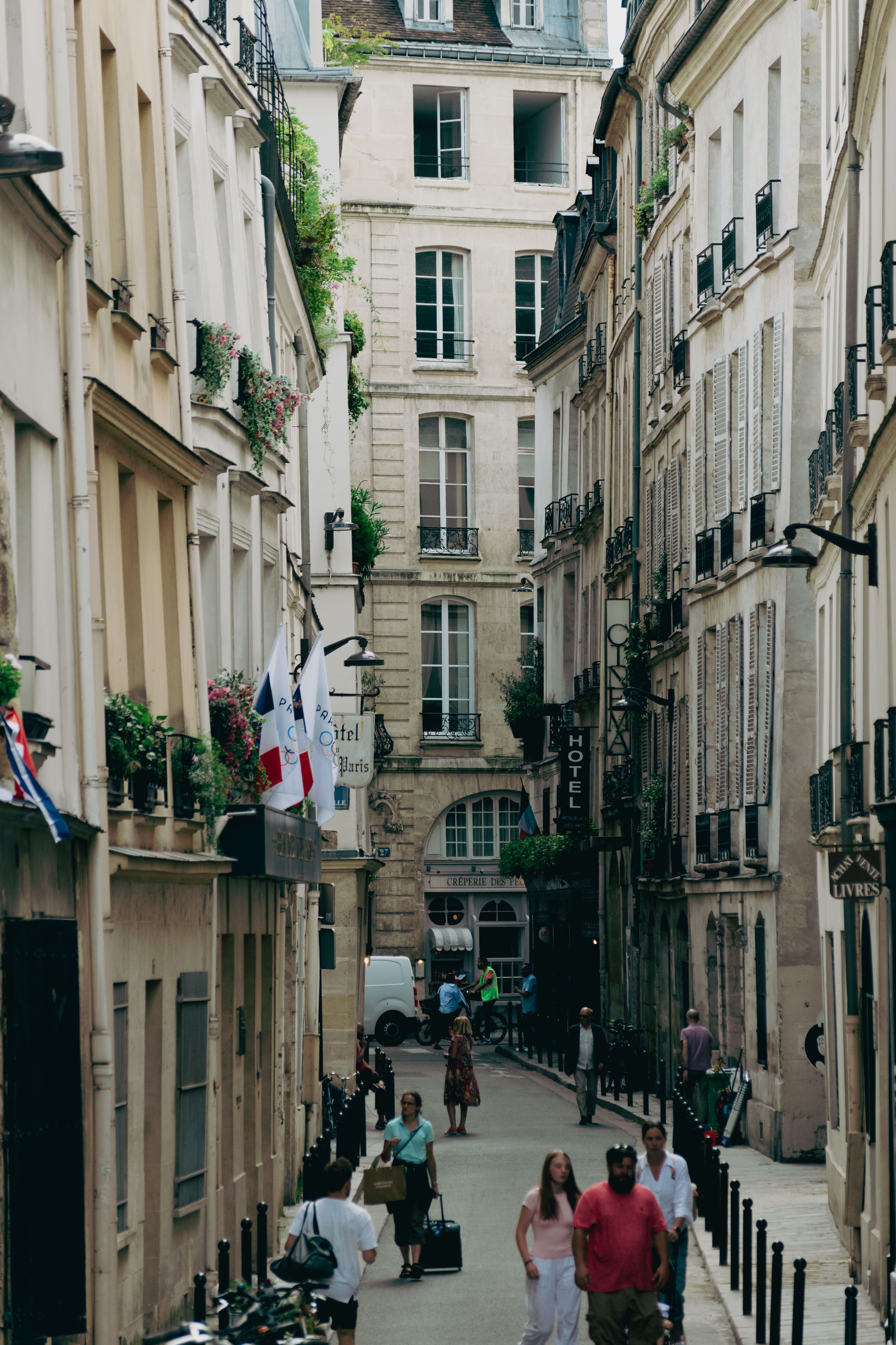 A narrow street with people walking down it · Free Stock Photo