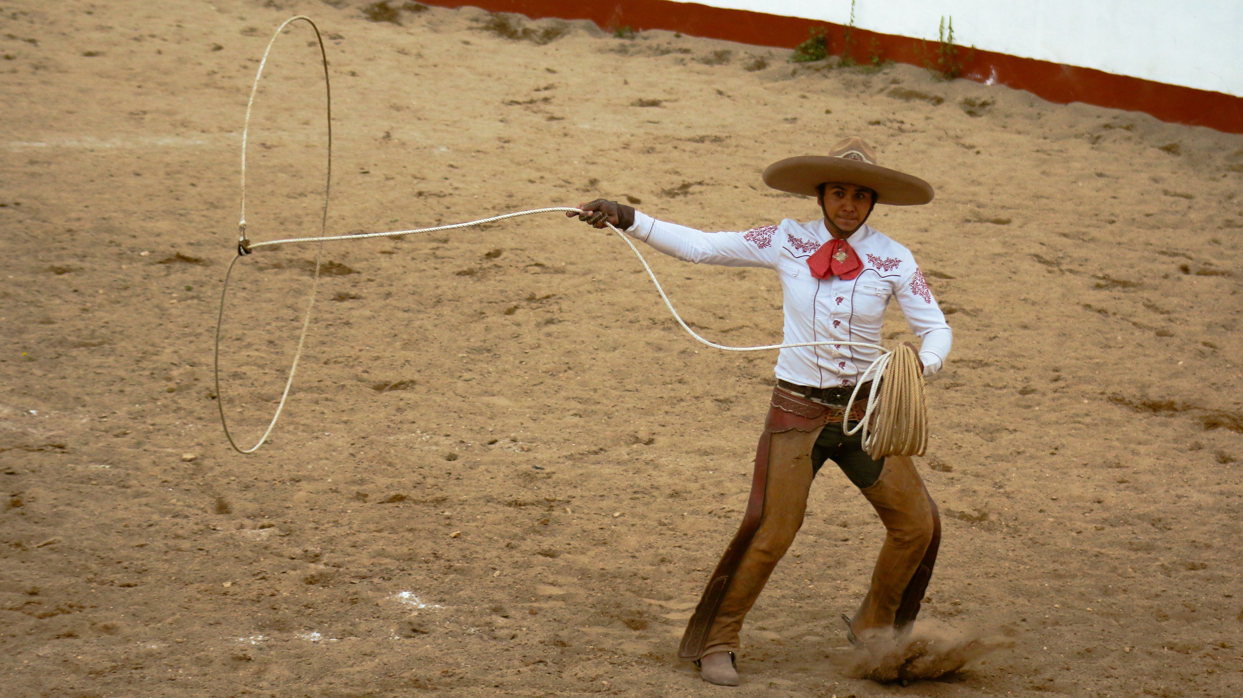 A man in a cowboy hat is holding a lasso · Free Stock Photo