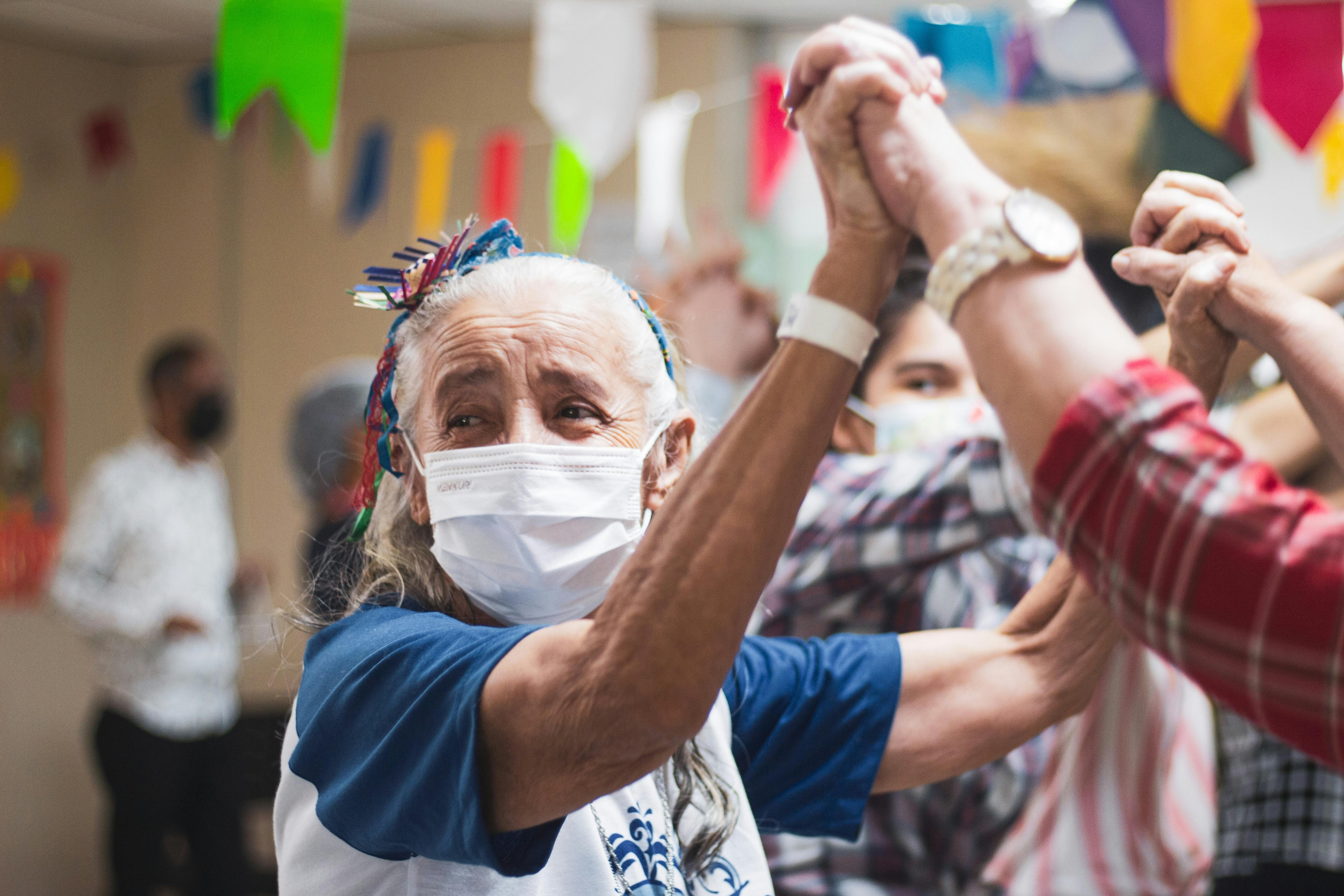 A group of people wearing face masks dance together · Free Stock Photo