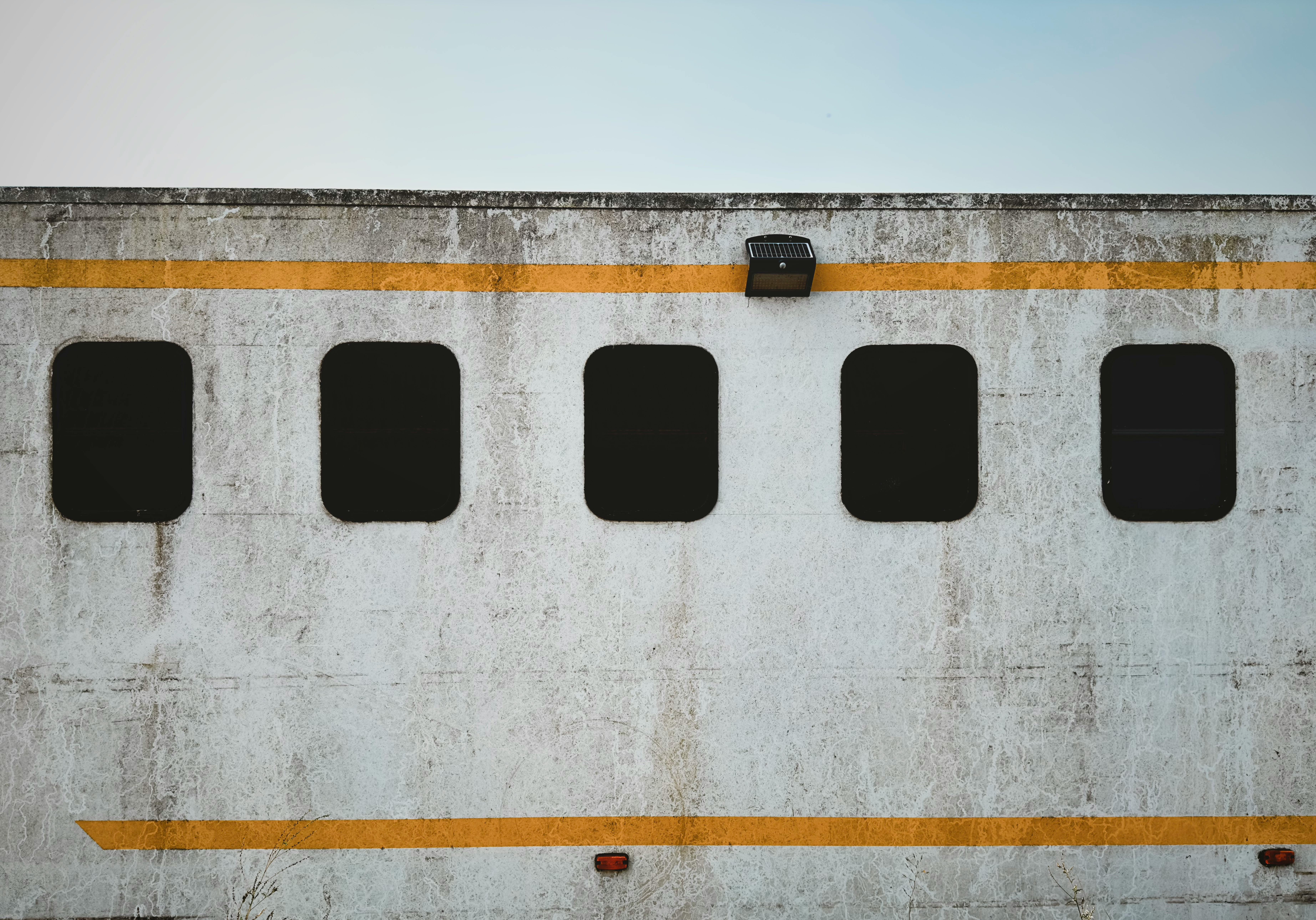 A white train with windows and yellow lines · Free Stock Photo