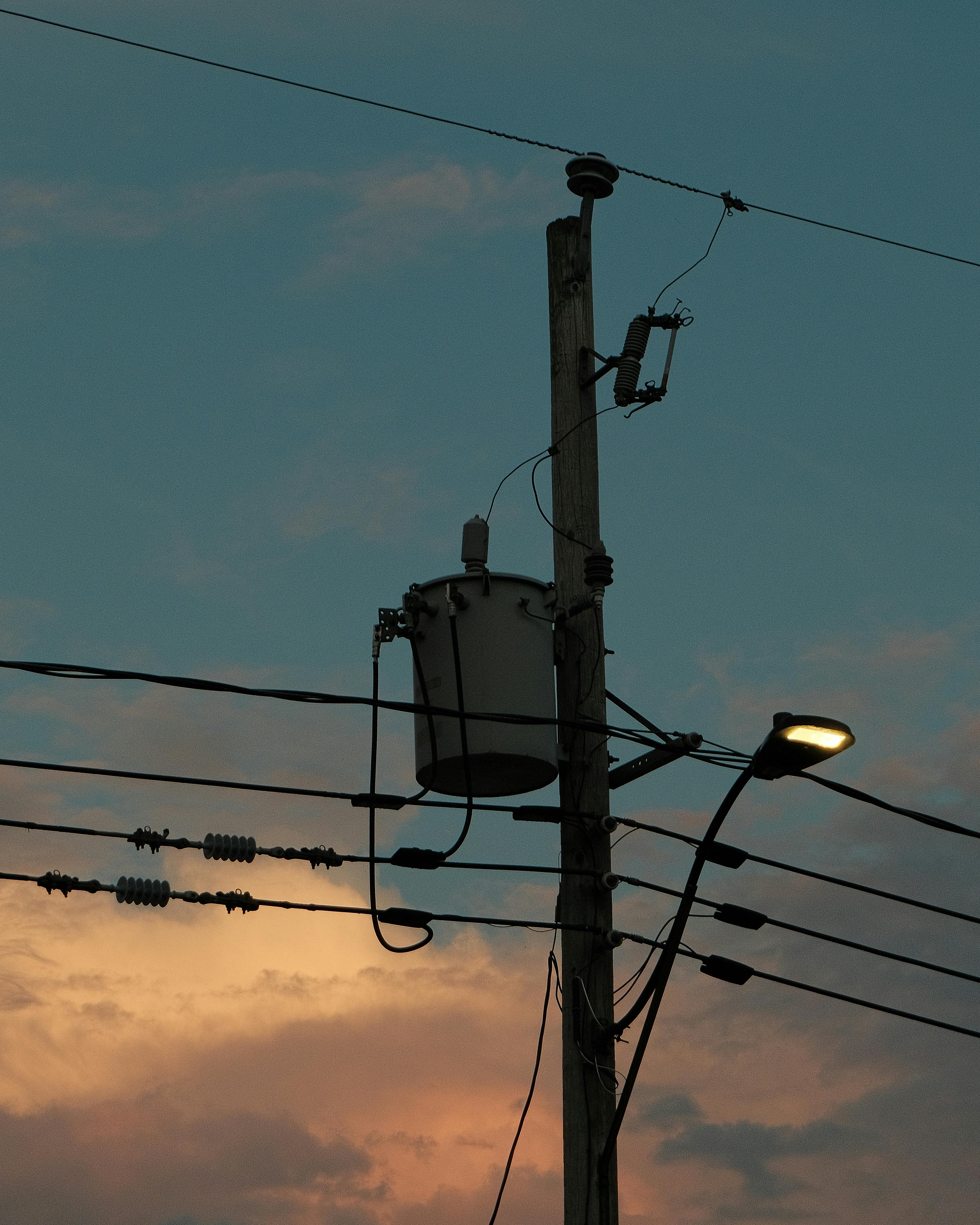 A power pole with a street light and a sunset · Free Stock Photo
