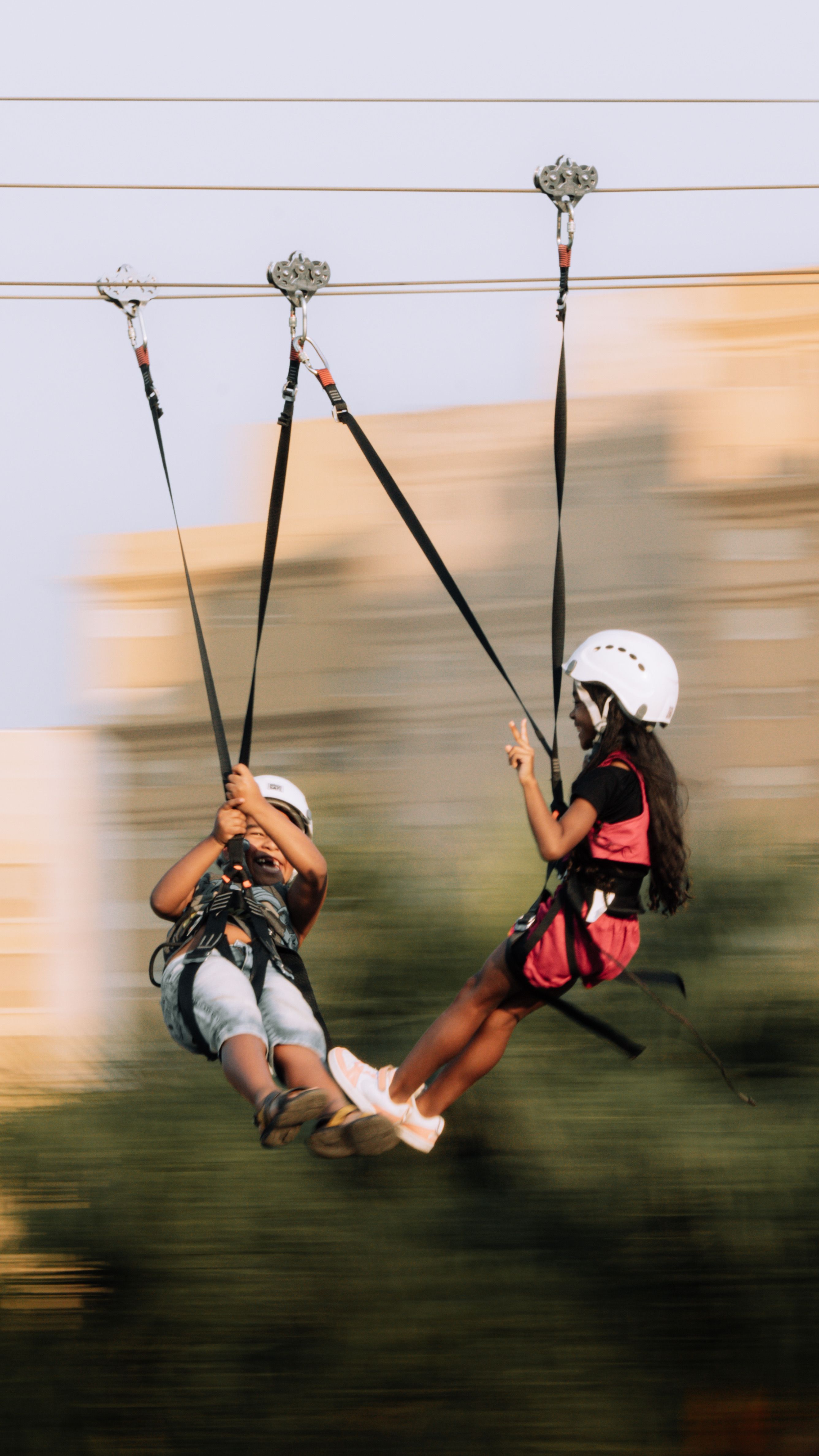 Two people riding on a zip line in the city · Free Stock Photo