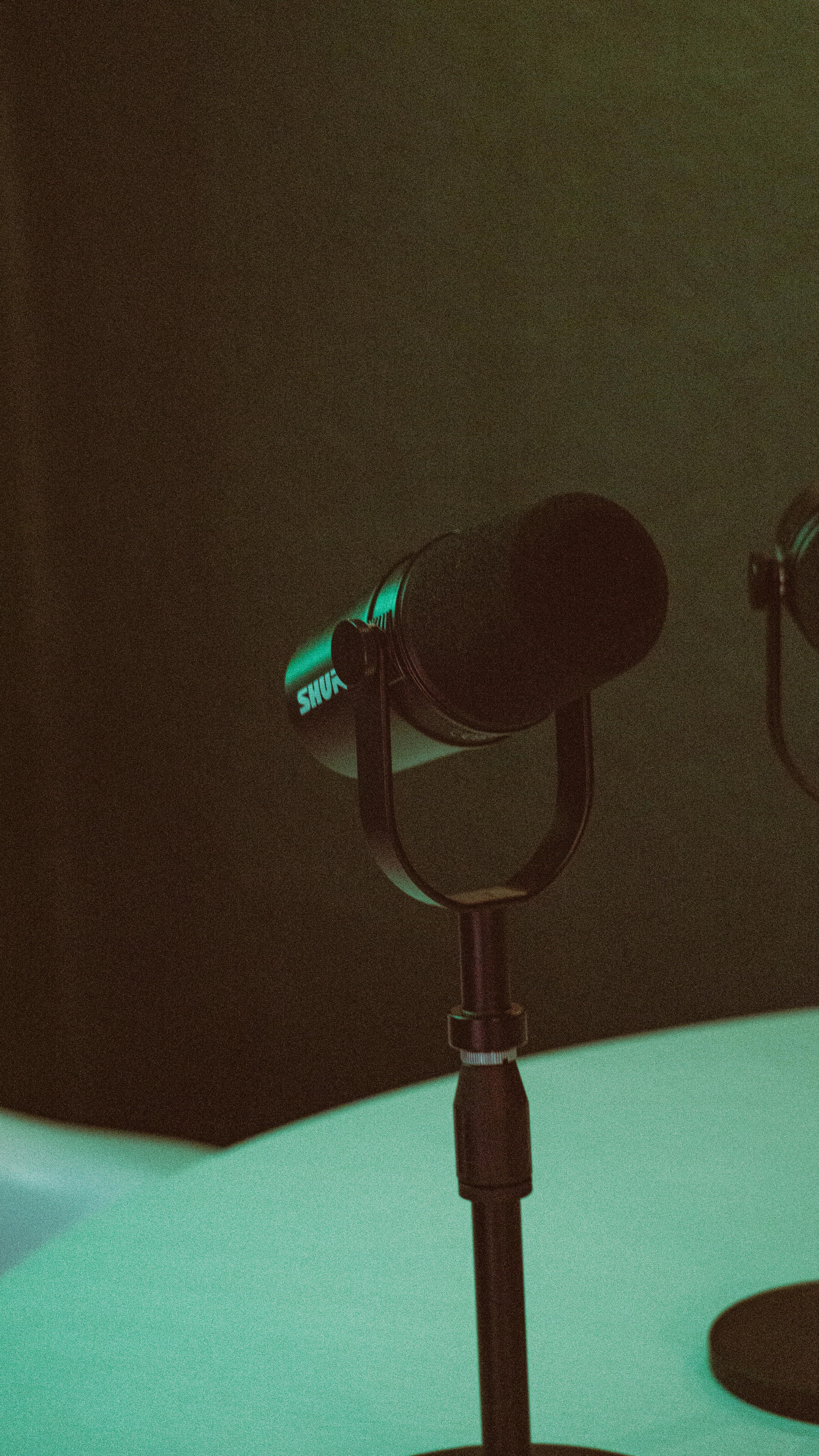 Two microphones on a table with green lights · Free Stock Photo
