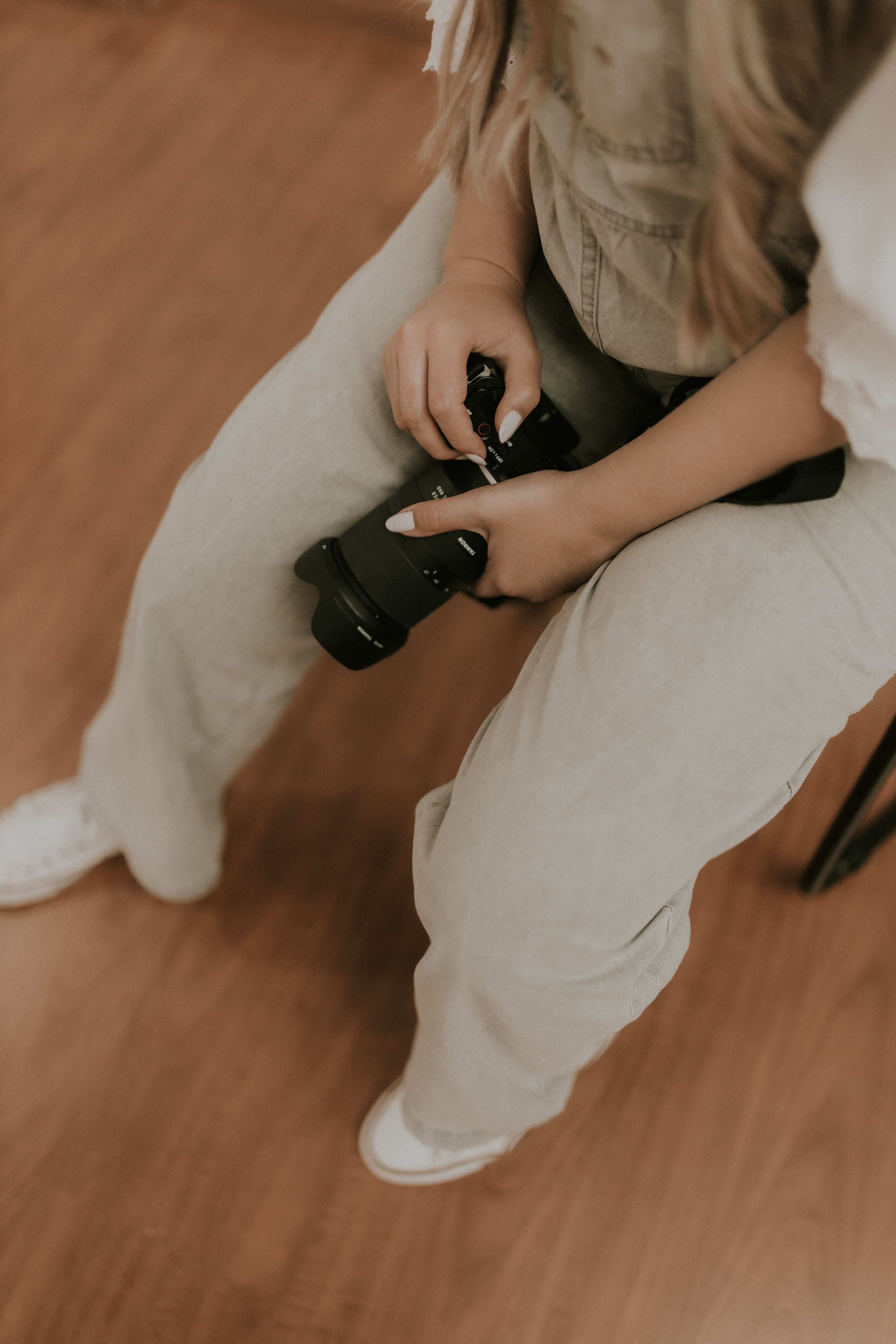 A woman sitting on a chair holding a camera · Free Stock Photo