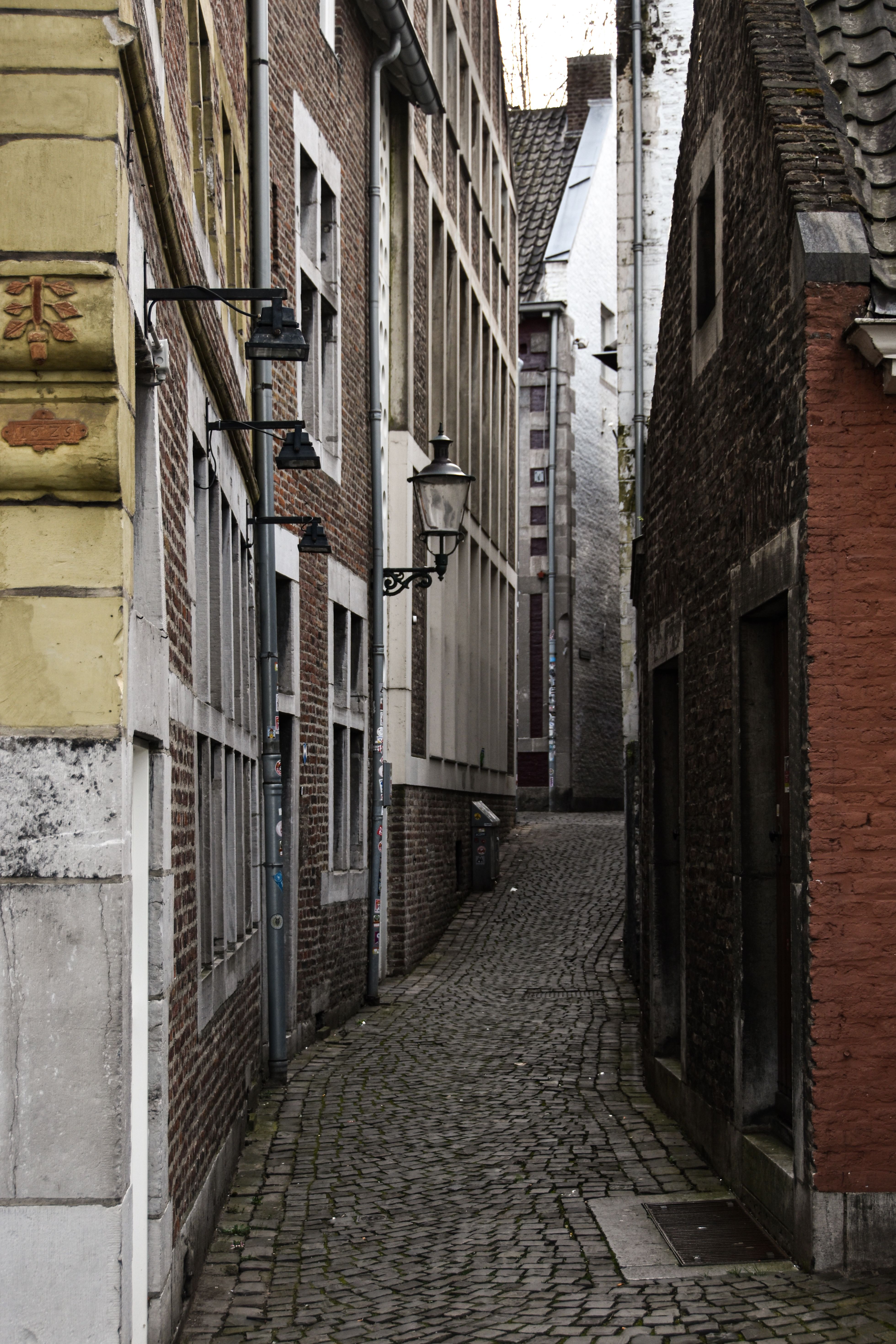 A narrow alleyway with brick buildings on both sides · Free Stock Photo